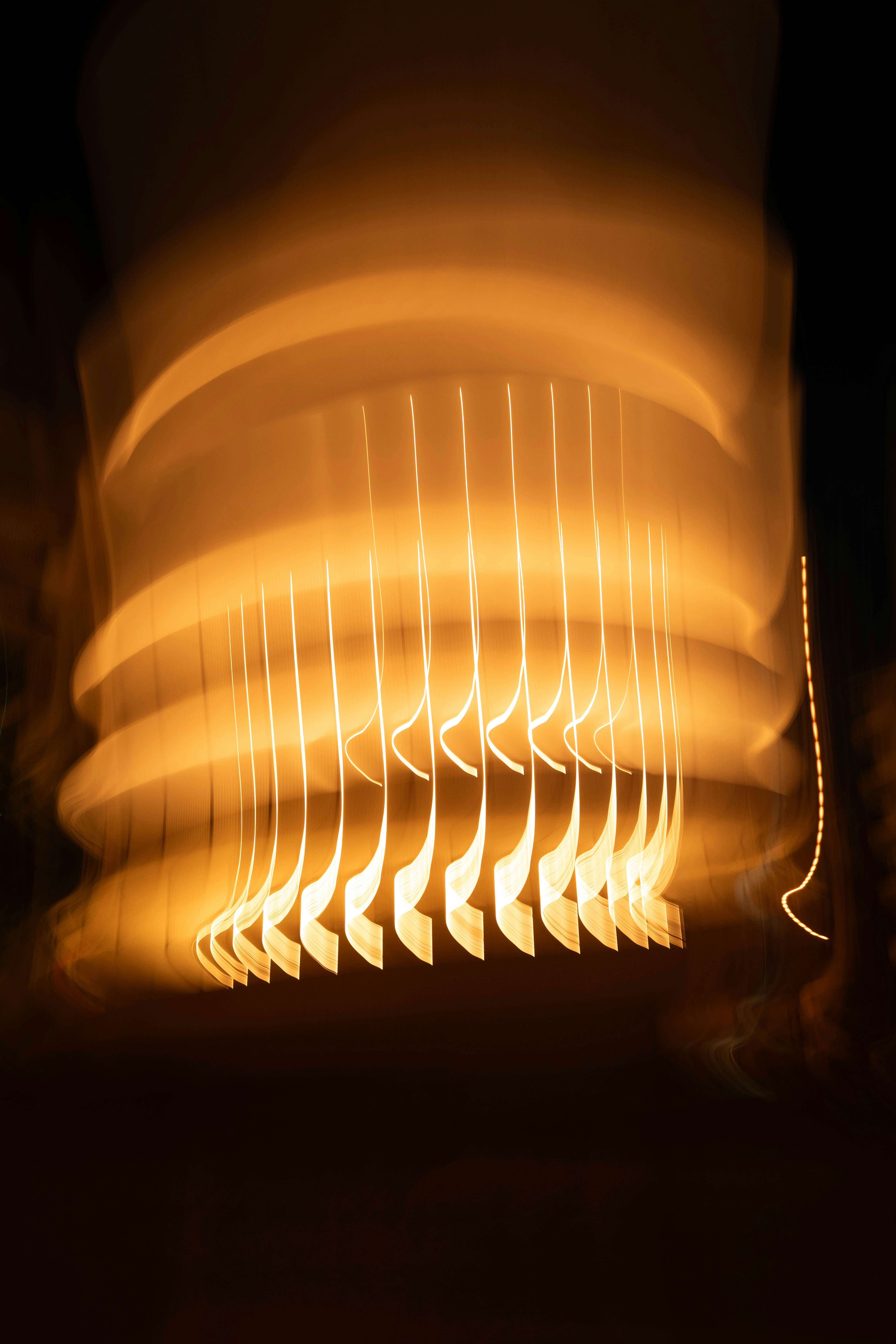 Abstract golden light trails creating a rhythmic pattern against a dark background