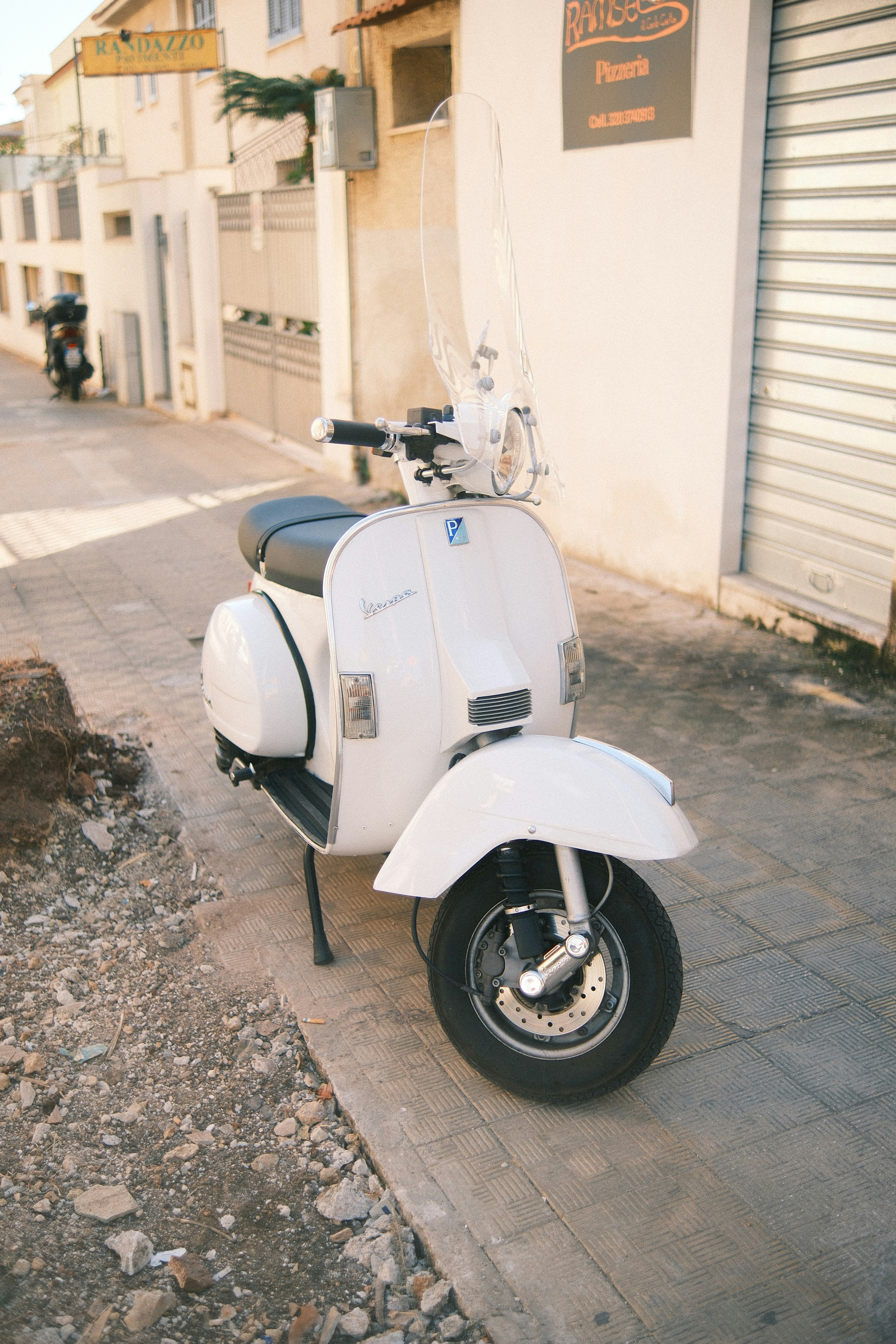 Ole White: A Quiet Vespa Stands Guard on a Sunlit Street