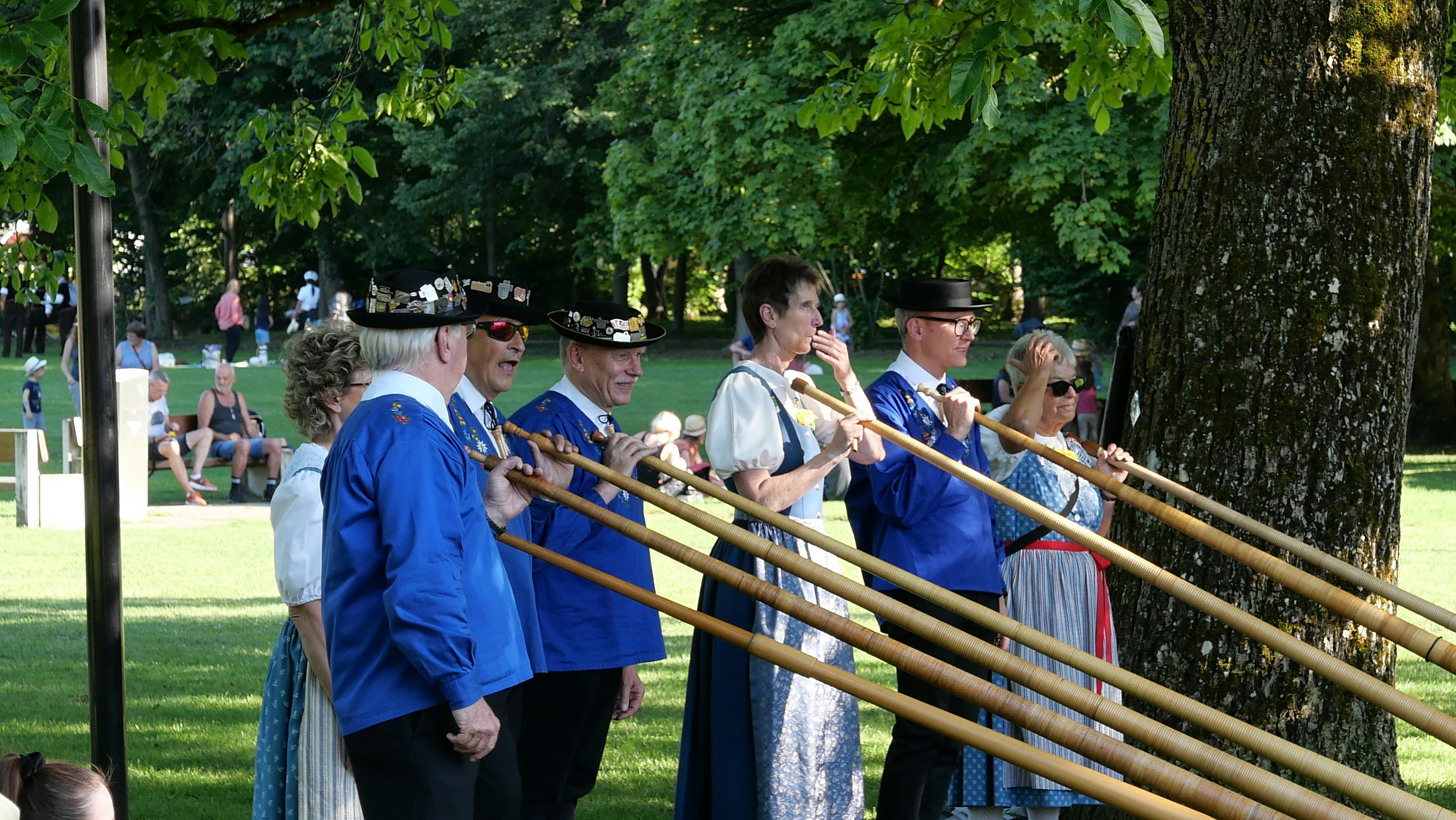 A Legacy of Song: Musicians in Blue Vests Line the Park with Long Flutes