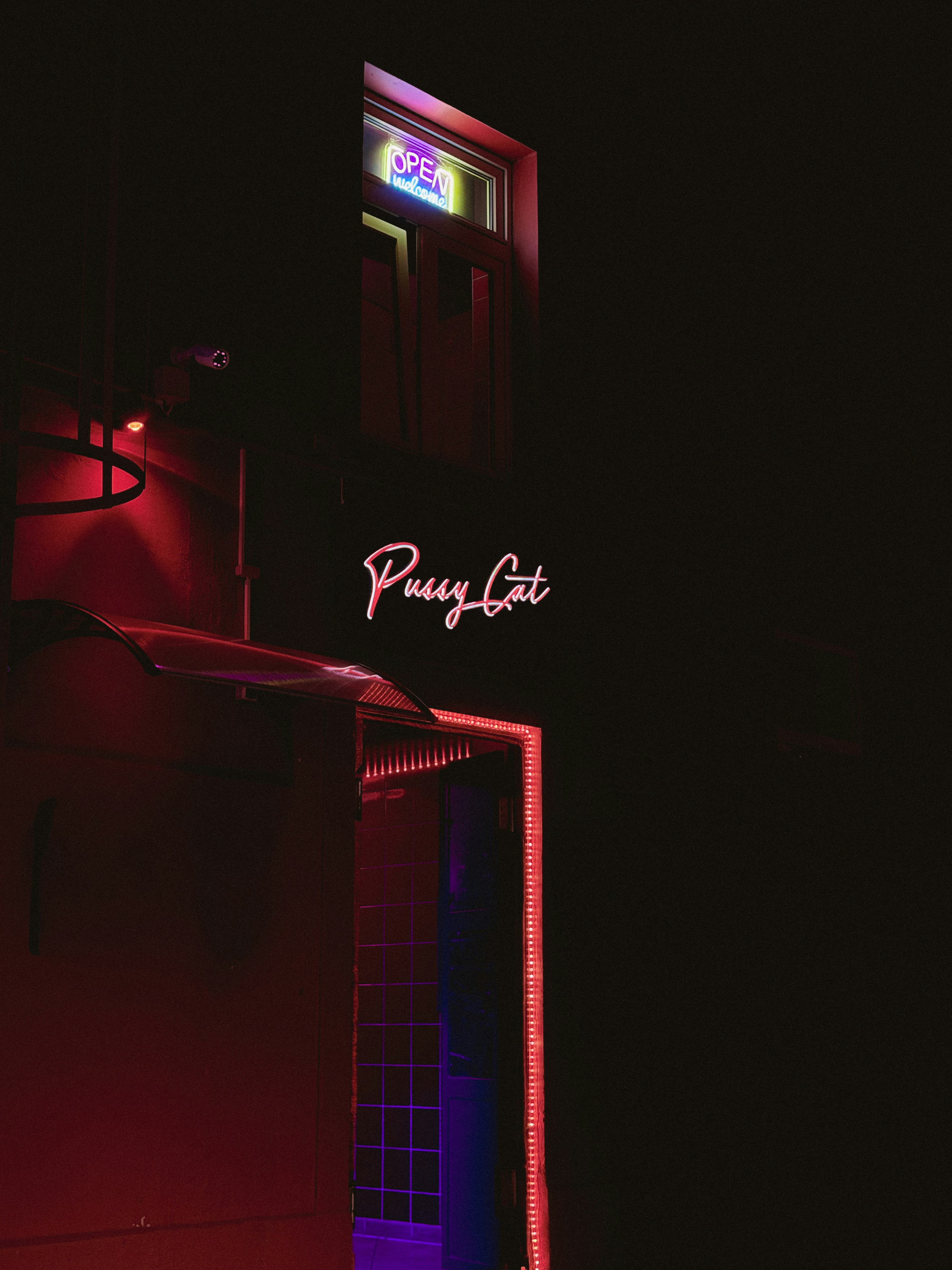 Neon Exit: Nightlife Signage Illuminates a Quiet Facade