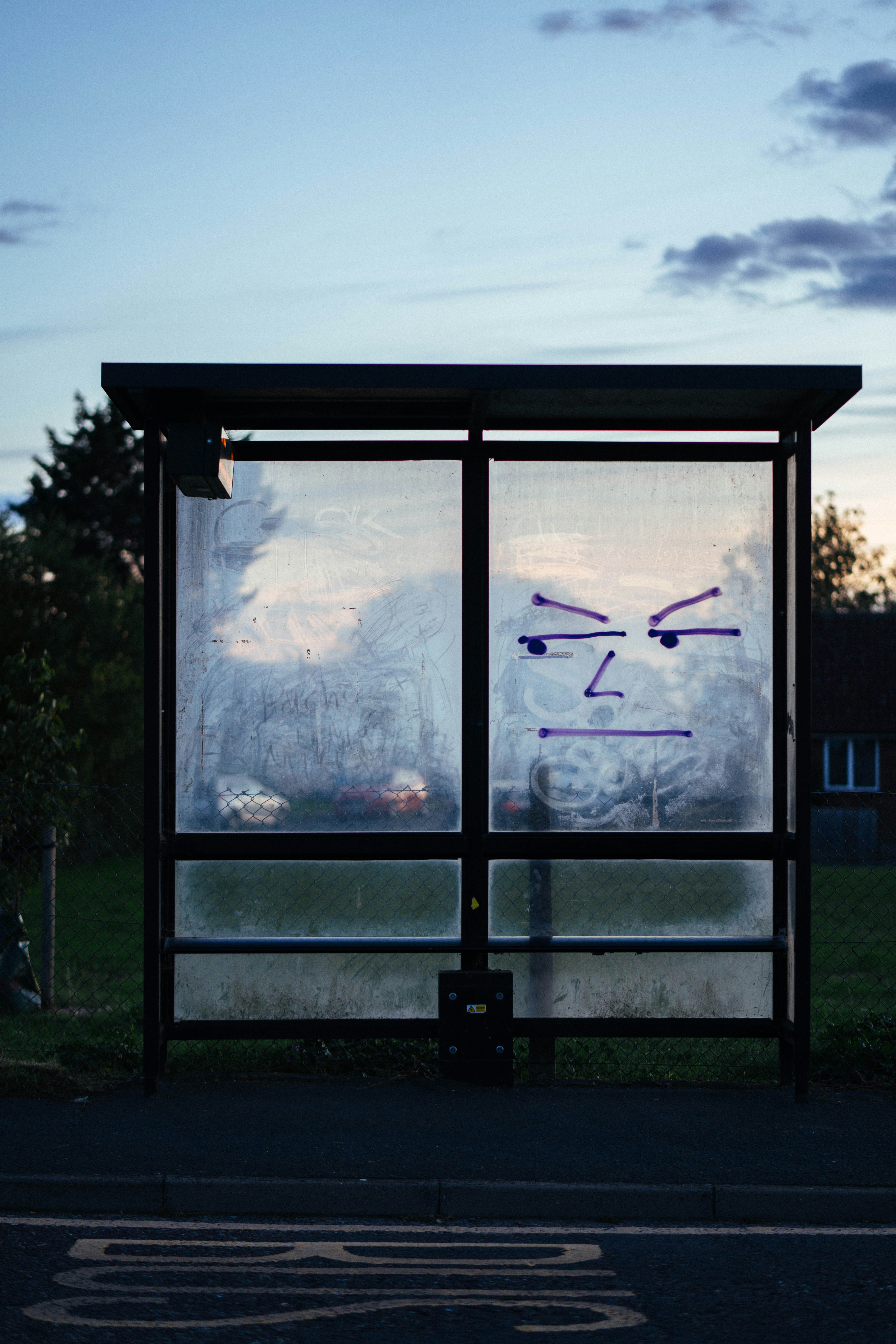 Graffiti Face on a Quiet Bus Shelter at Dusk