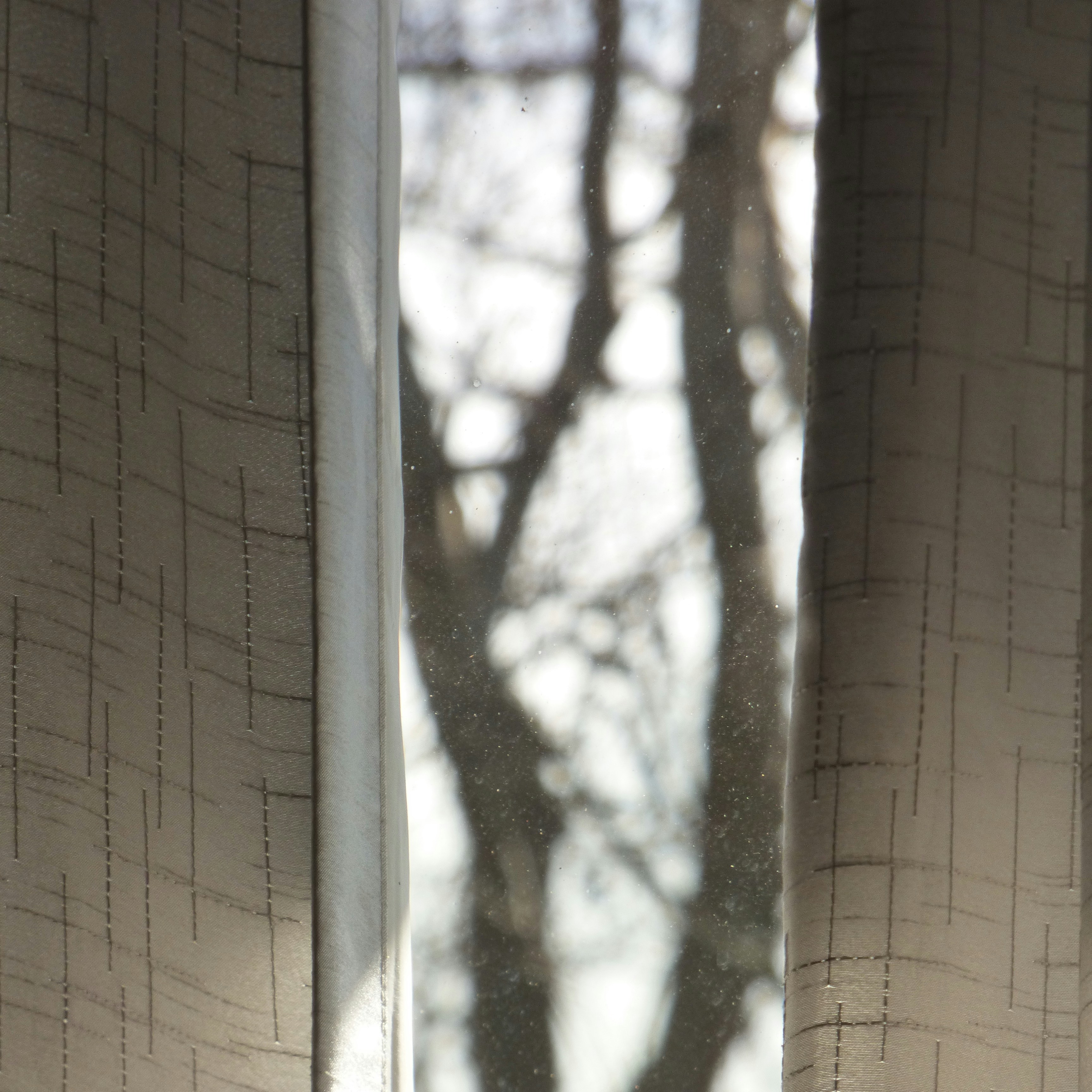 Between the Curtains: Snowflakes in a Quiet Window Gap