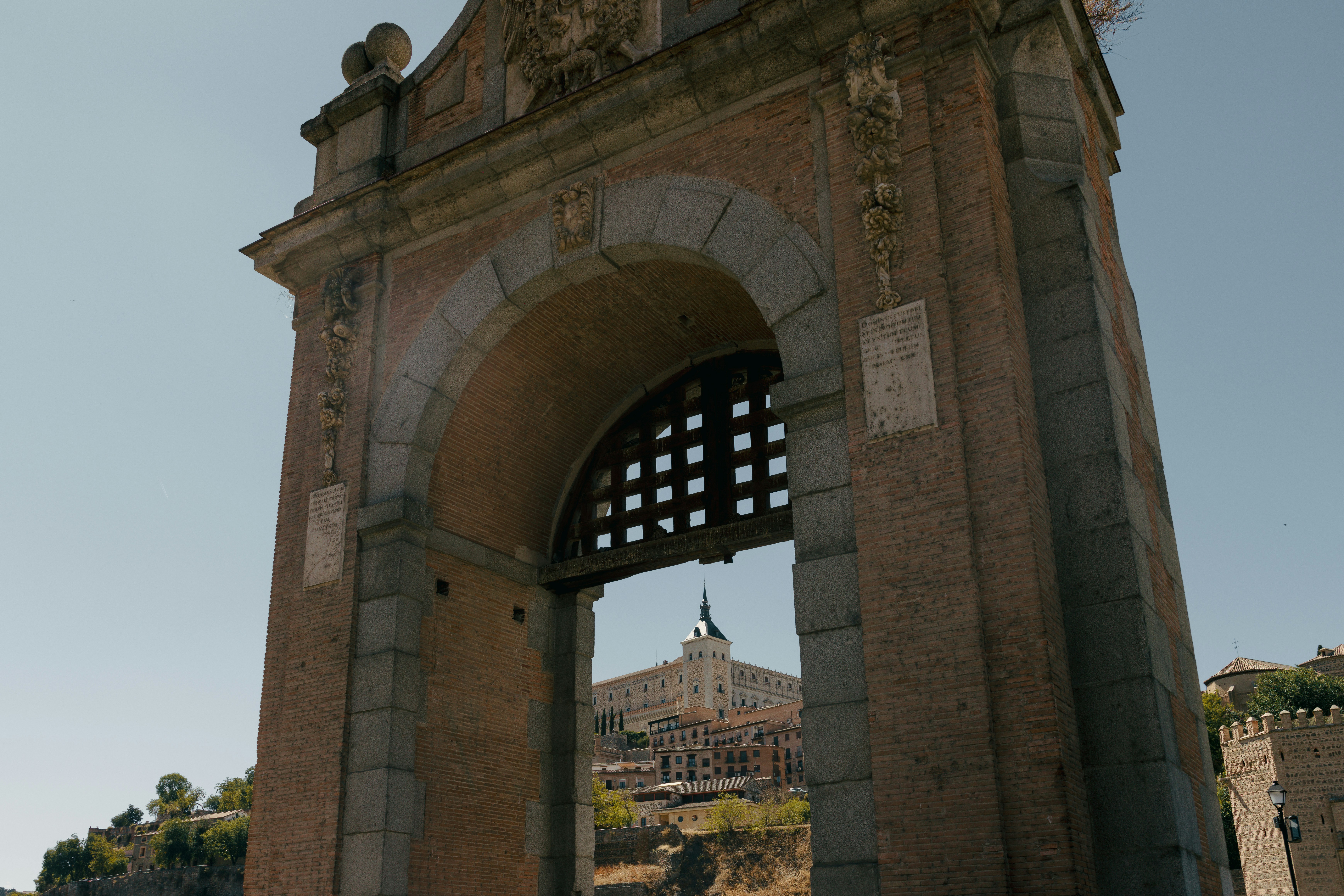 Through the Arch: A Sunlit Gate Framing a Mellow Hilltop Castle