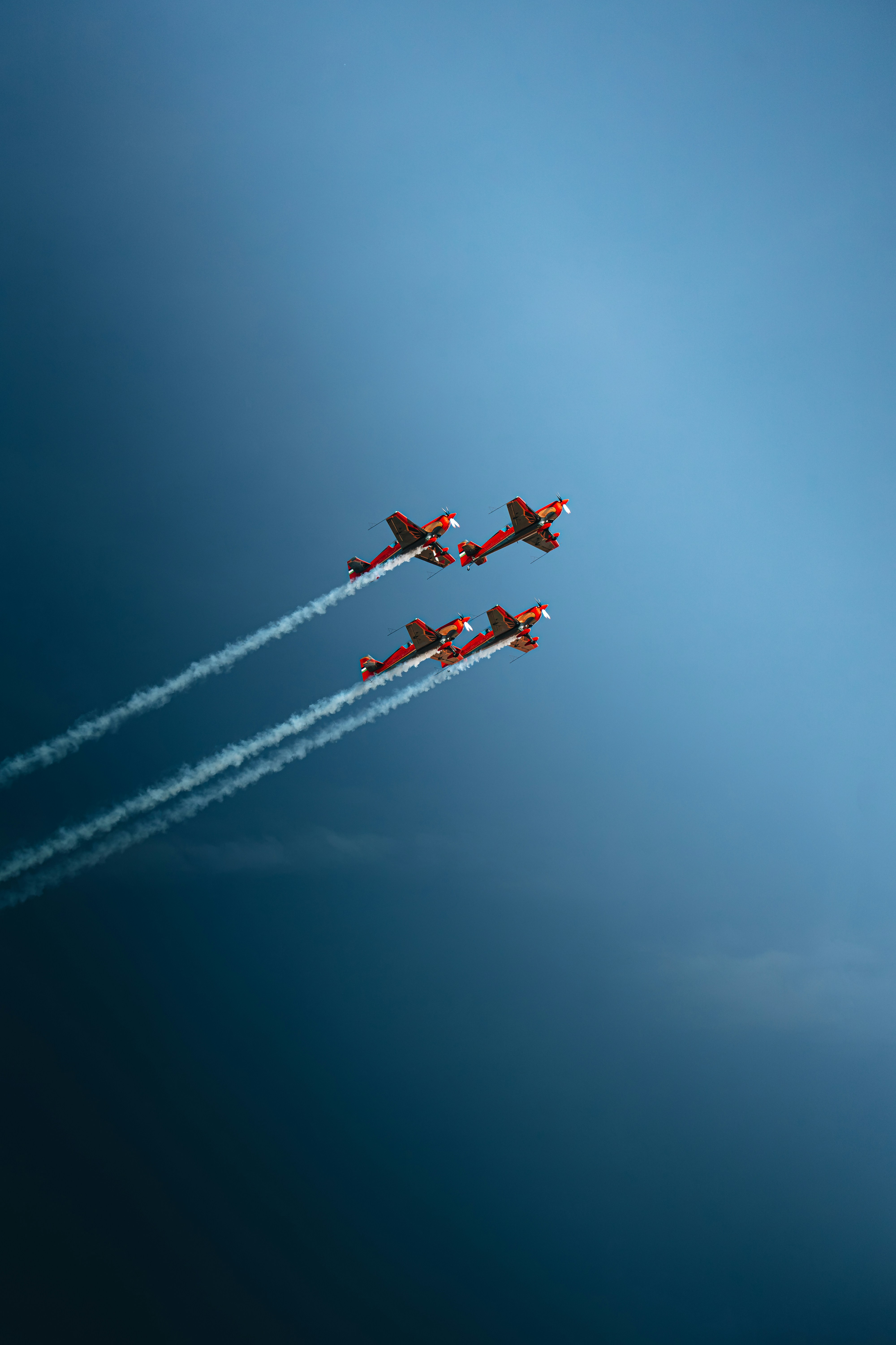 Triad in the Bright Sky: Red Aircraft Circling in Formation