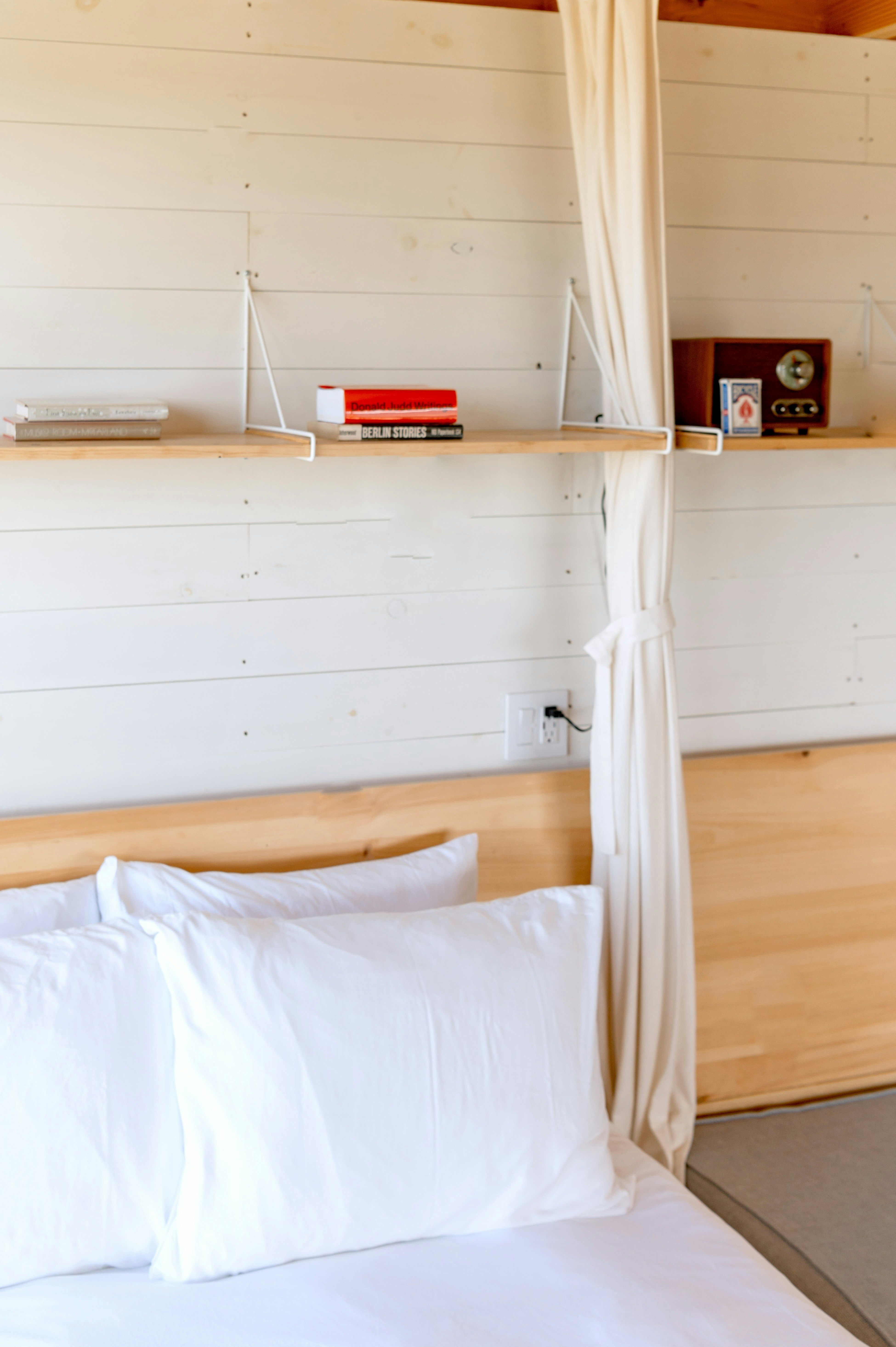 Minimalist White Bedroom with Floating Shelves and Vintage Radio