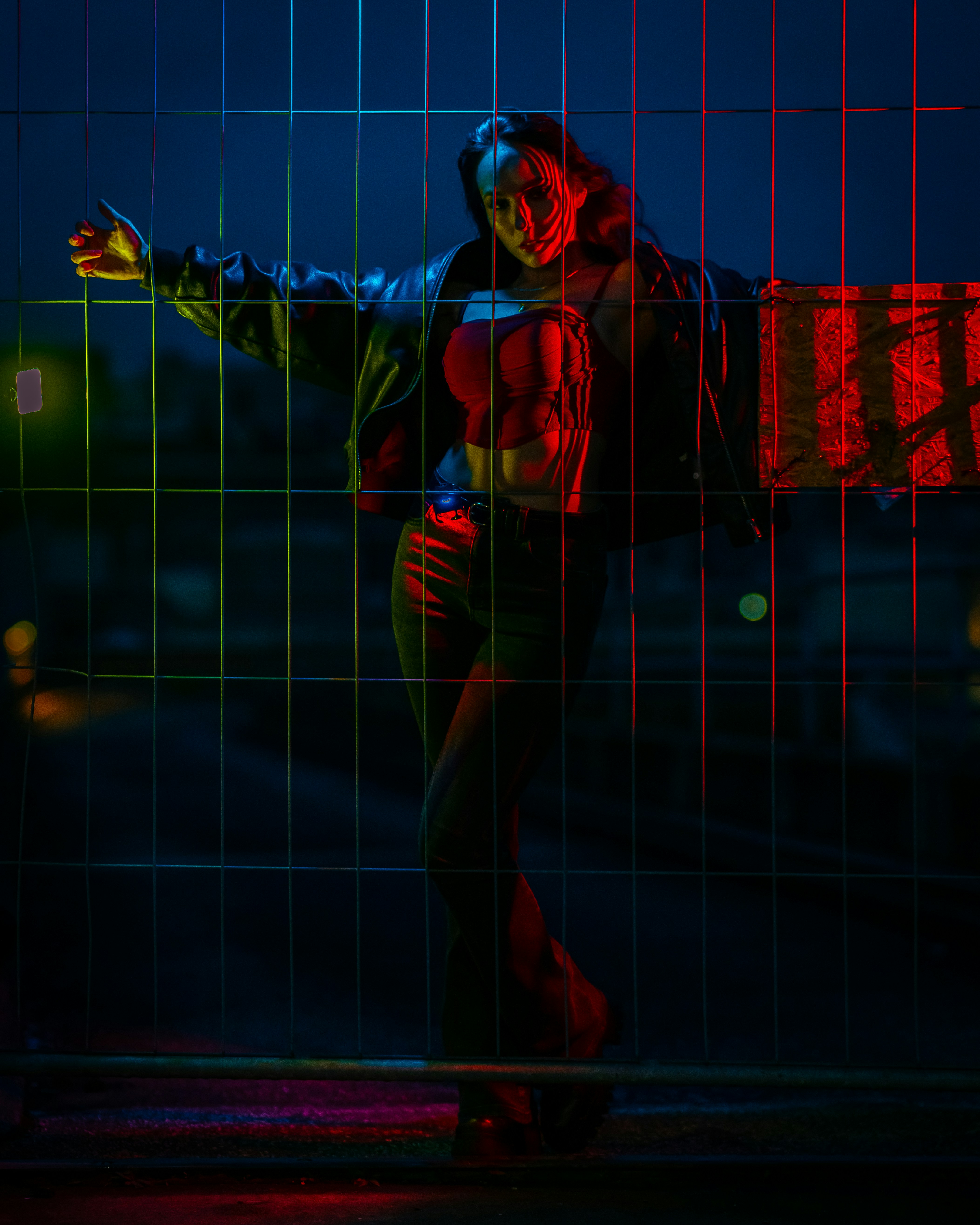 Neon Grid Veil: A Dusk Portrait Behind Barbed Light