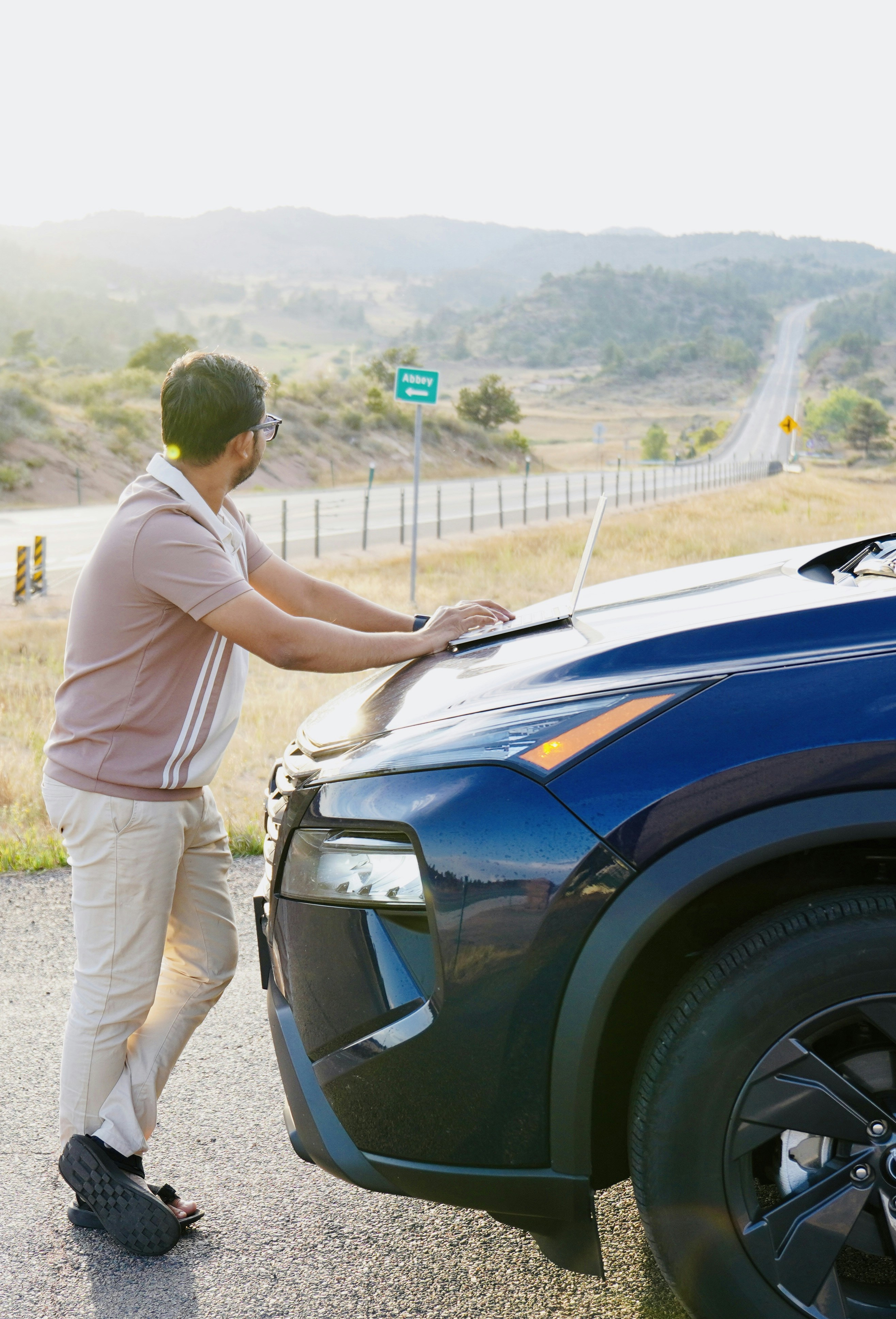Driver at the Horizon: A Moment of Prep beside a Bold Blue SUV