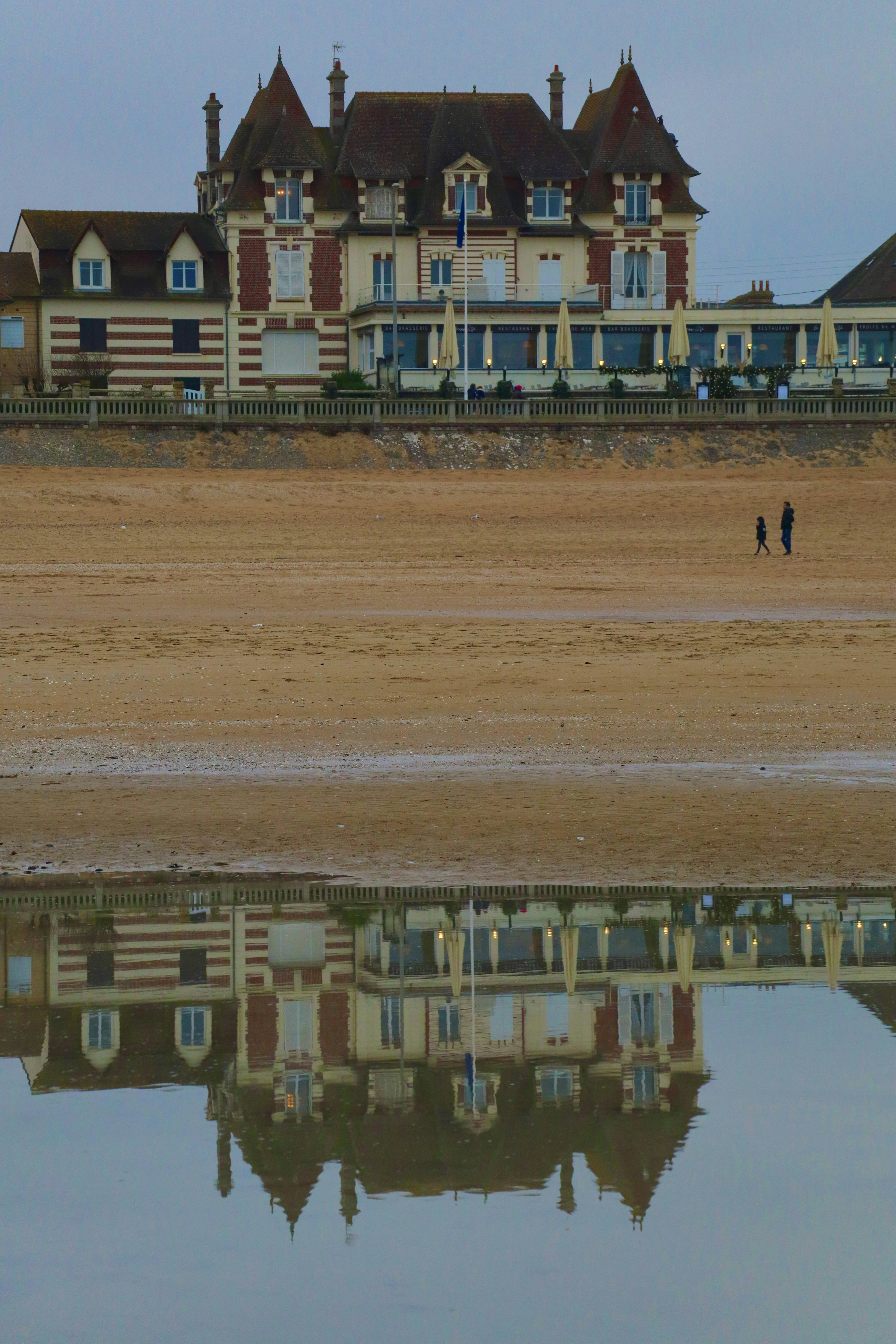 Festive seaside château: mirrored calm on the shore