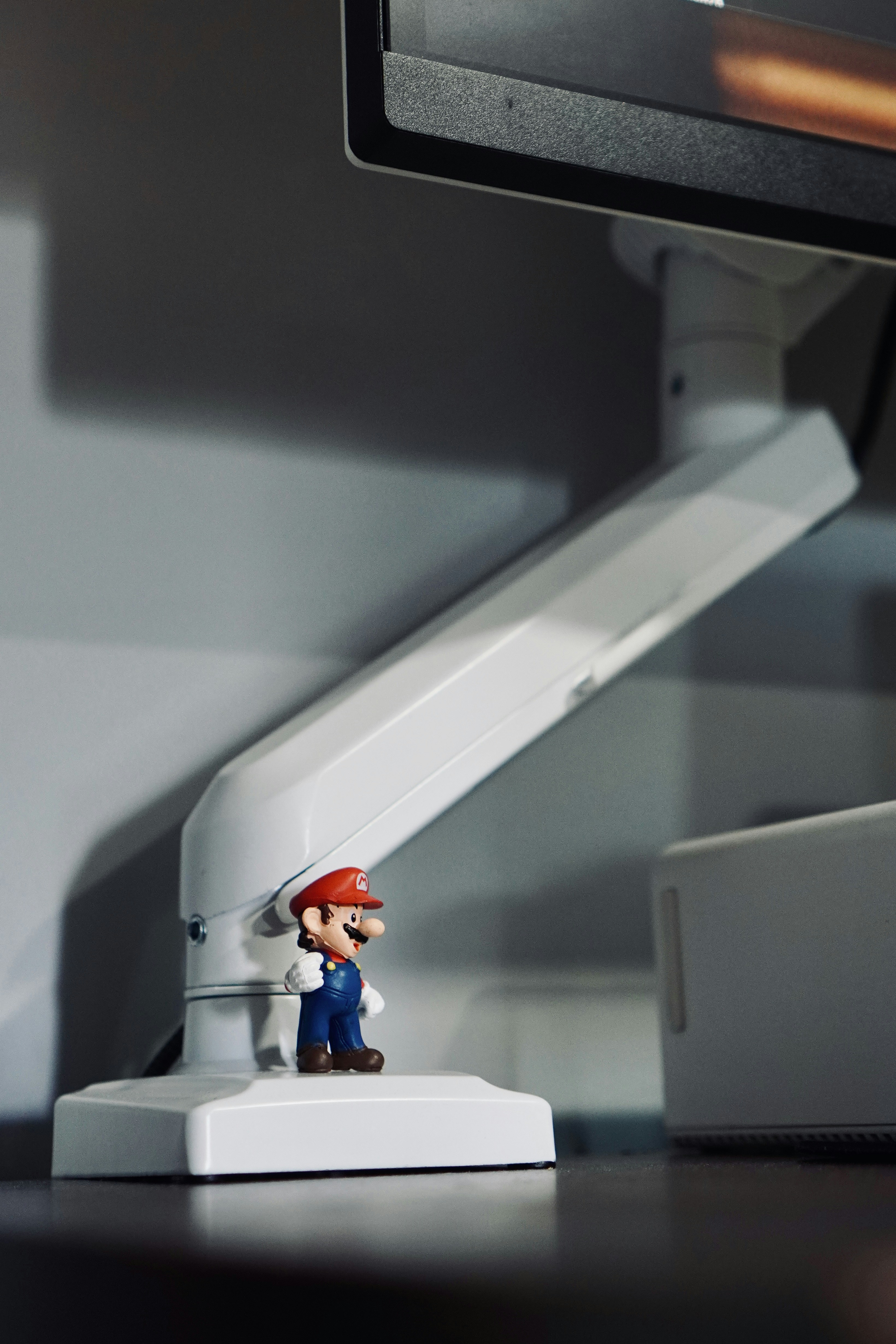 Mario meets the monitor lamp: a tiny plumber anchors a desk scene