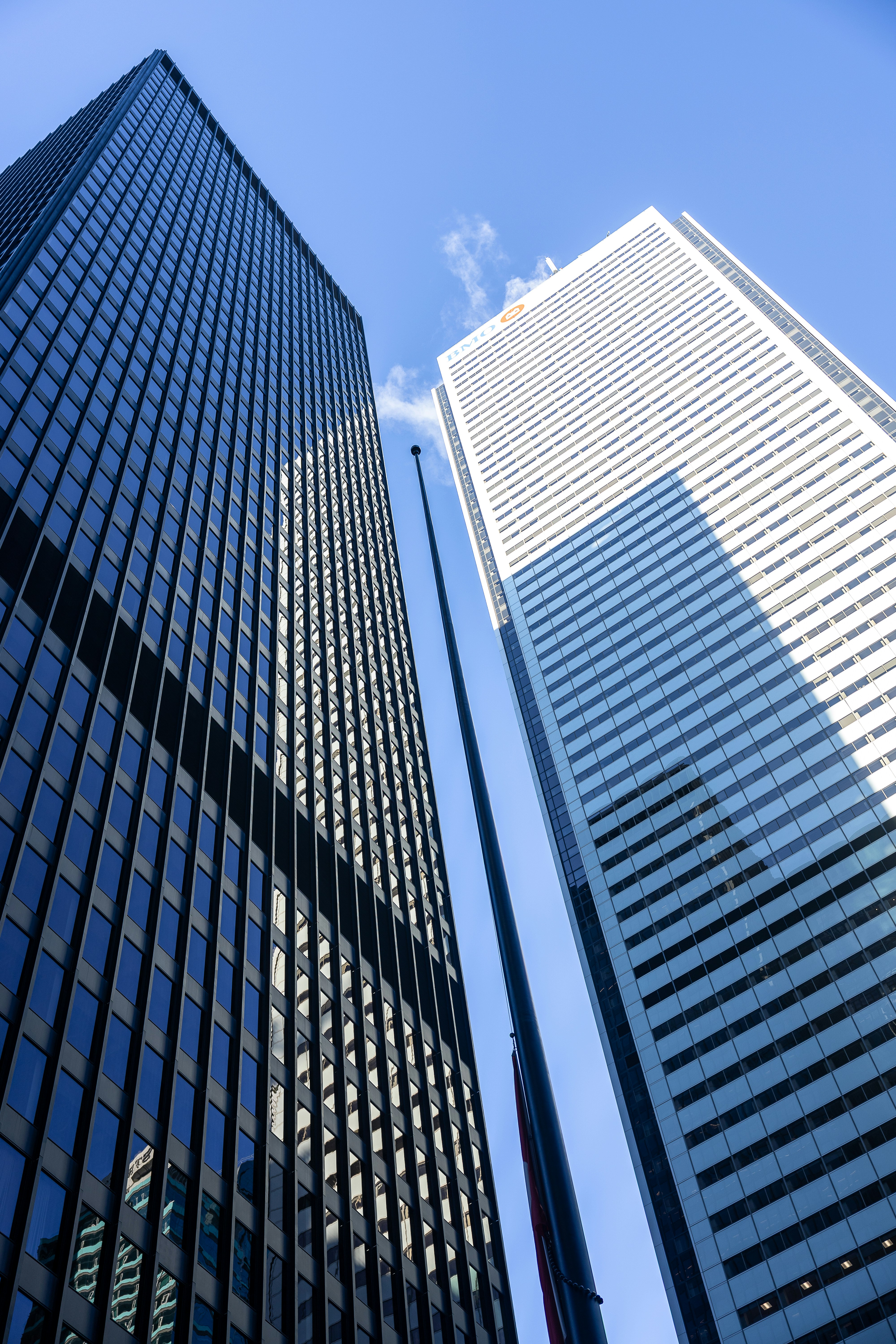 Toward the Sky: A Gap Between Skyscrapers Under Clear Blue