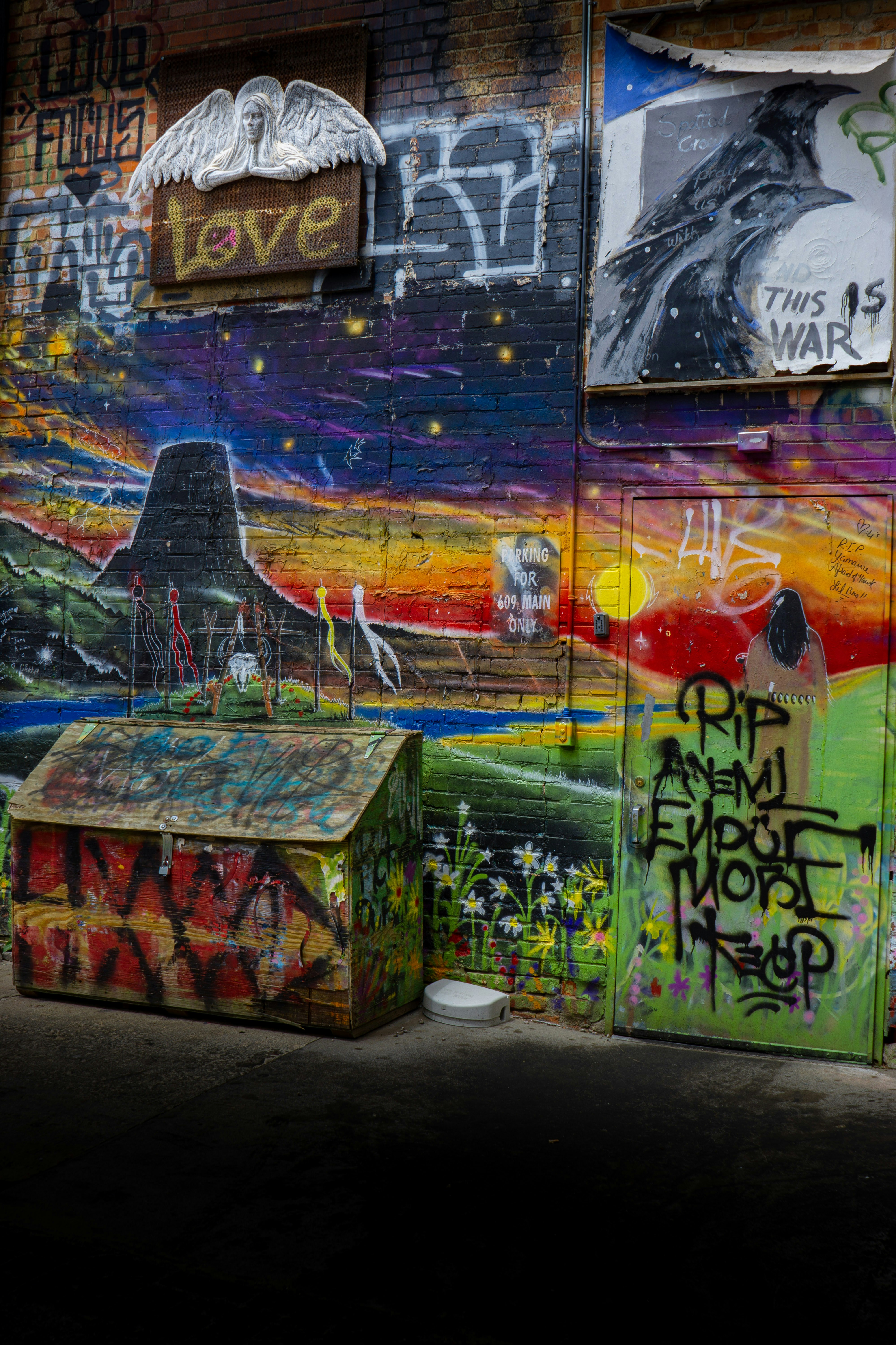 Wall of Color: A Graffiti Scene with Sunset Horizon and Winged Sculpture