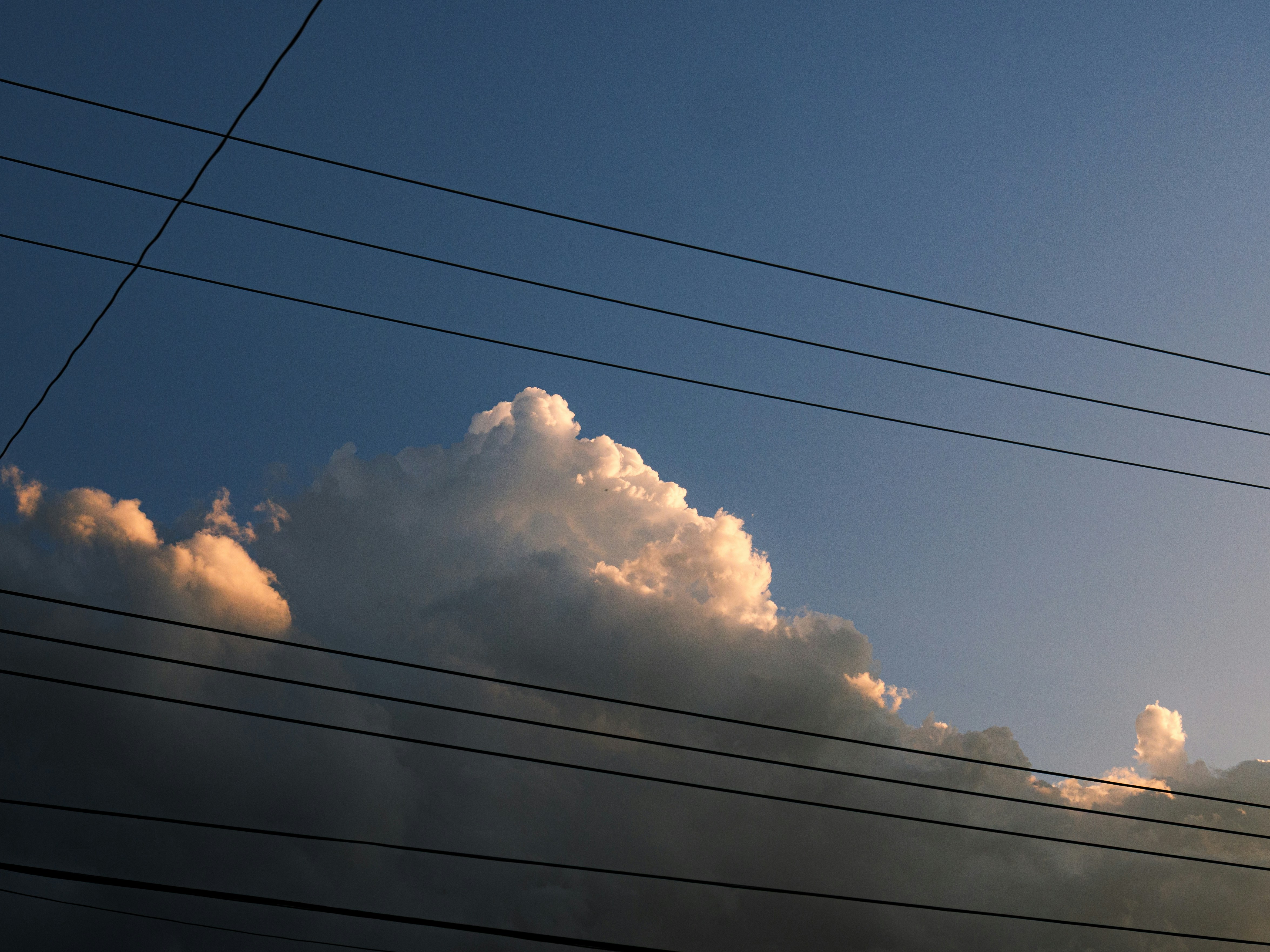 Skyline of Clouds and Power Lines under a Quiet Sundown