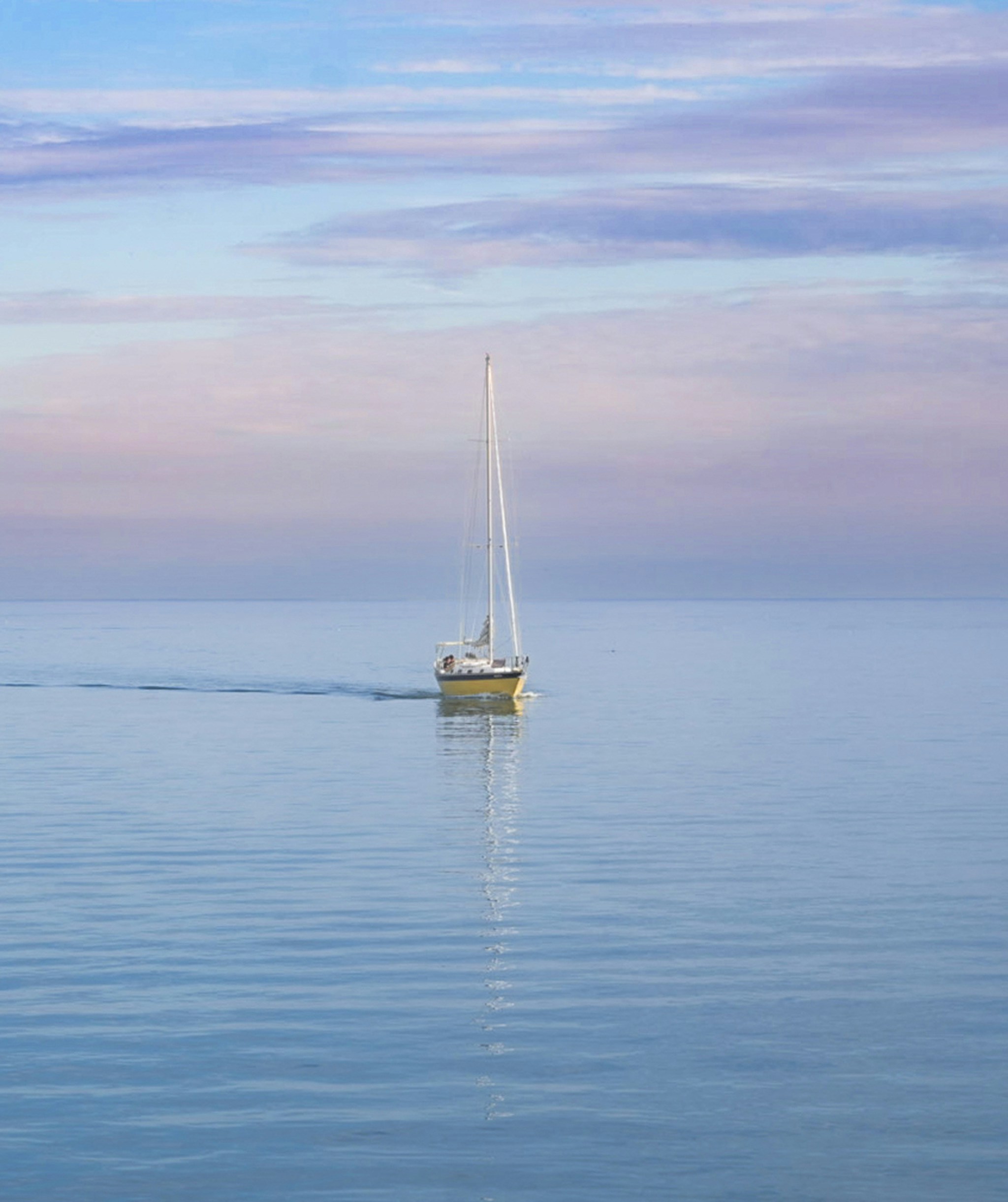 Yellow sailboat centers the calm sea with pastel sky; minimalist seascape emphasizing serenity and reflections.