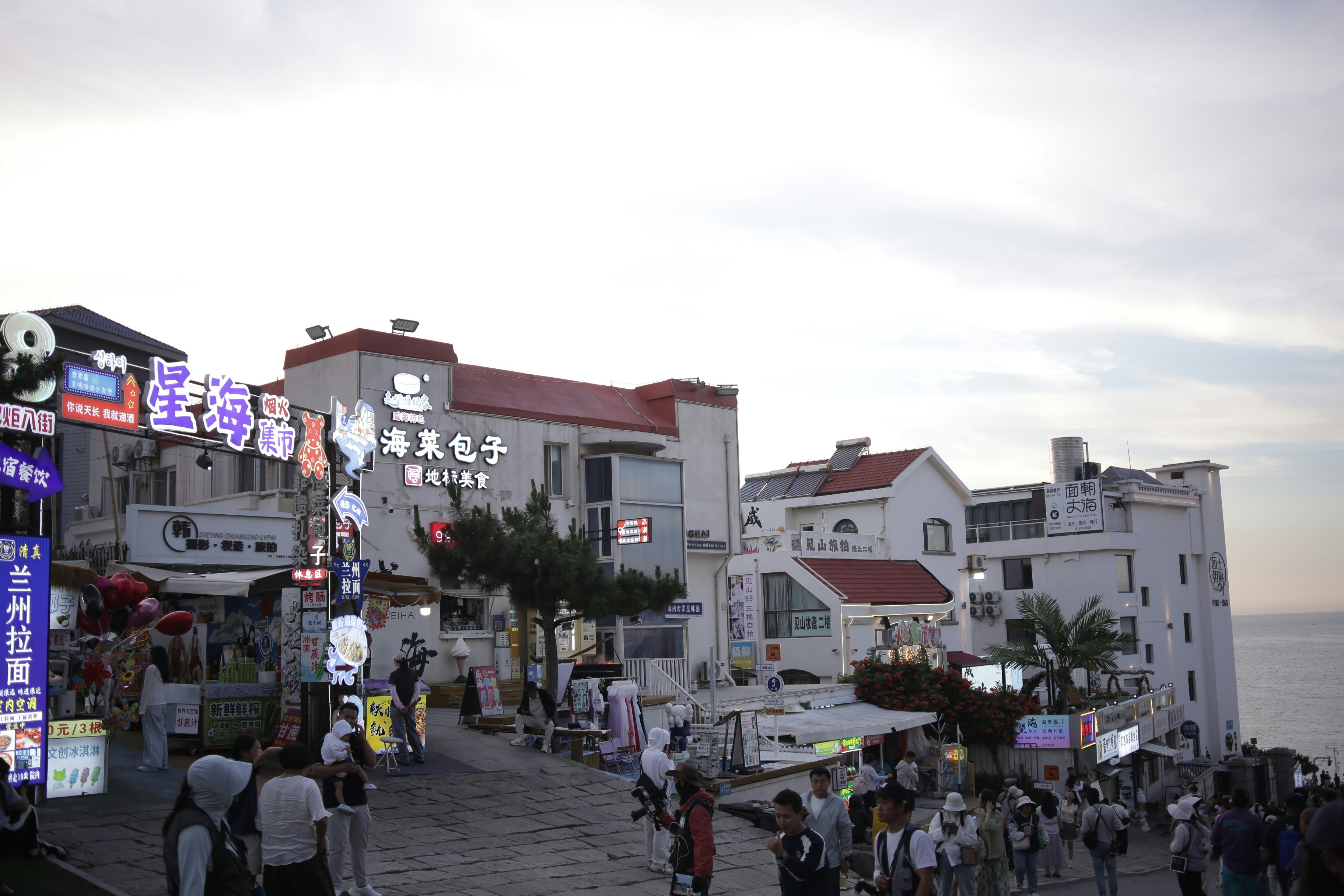 Sunlit Seaside Lane: A Bustling Coastal Street in Soft Evening Light