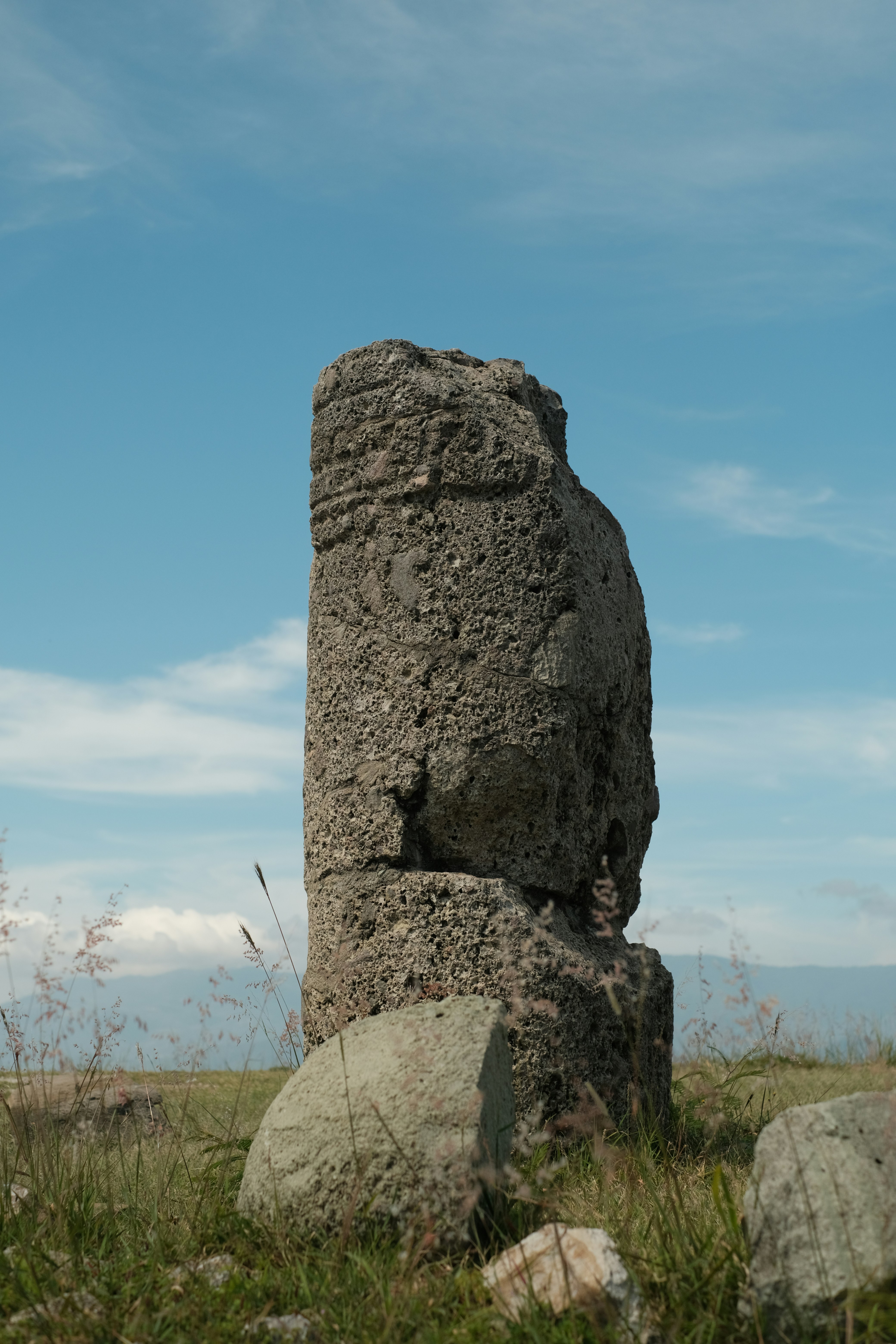 Ancient Sentinel: A Lone Stone Standing Against a Wide Blue Sky