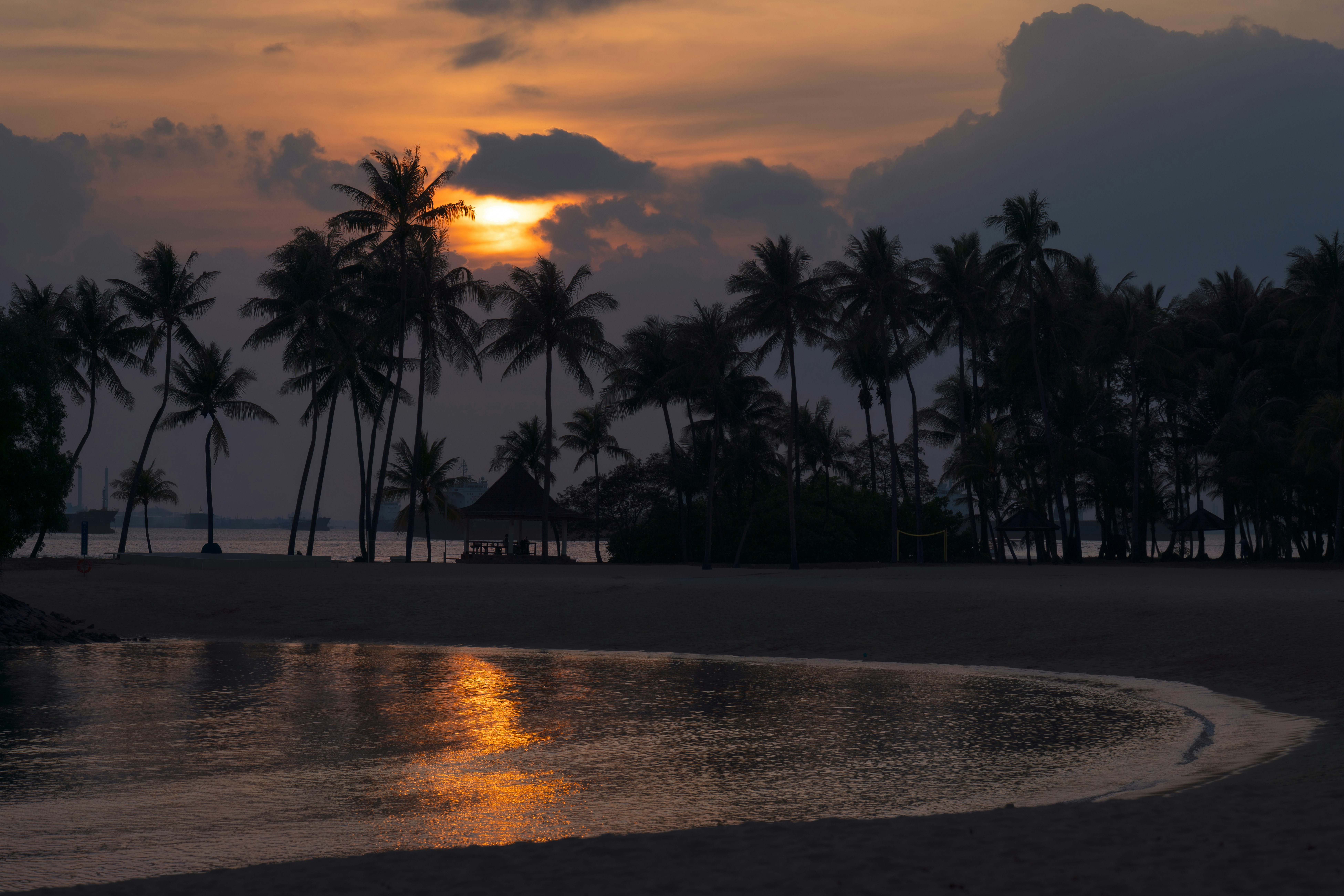 Sunset Silhouette over a Crescent Beach