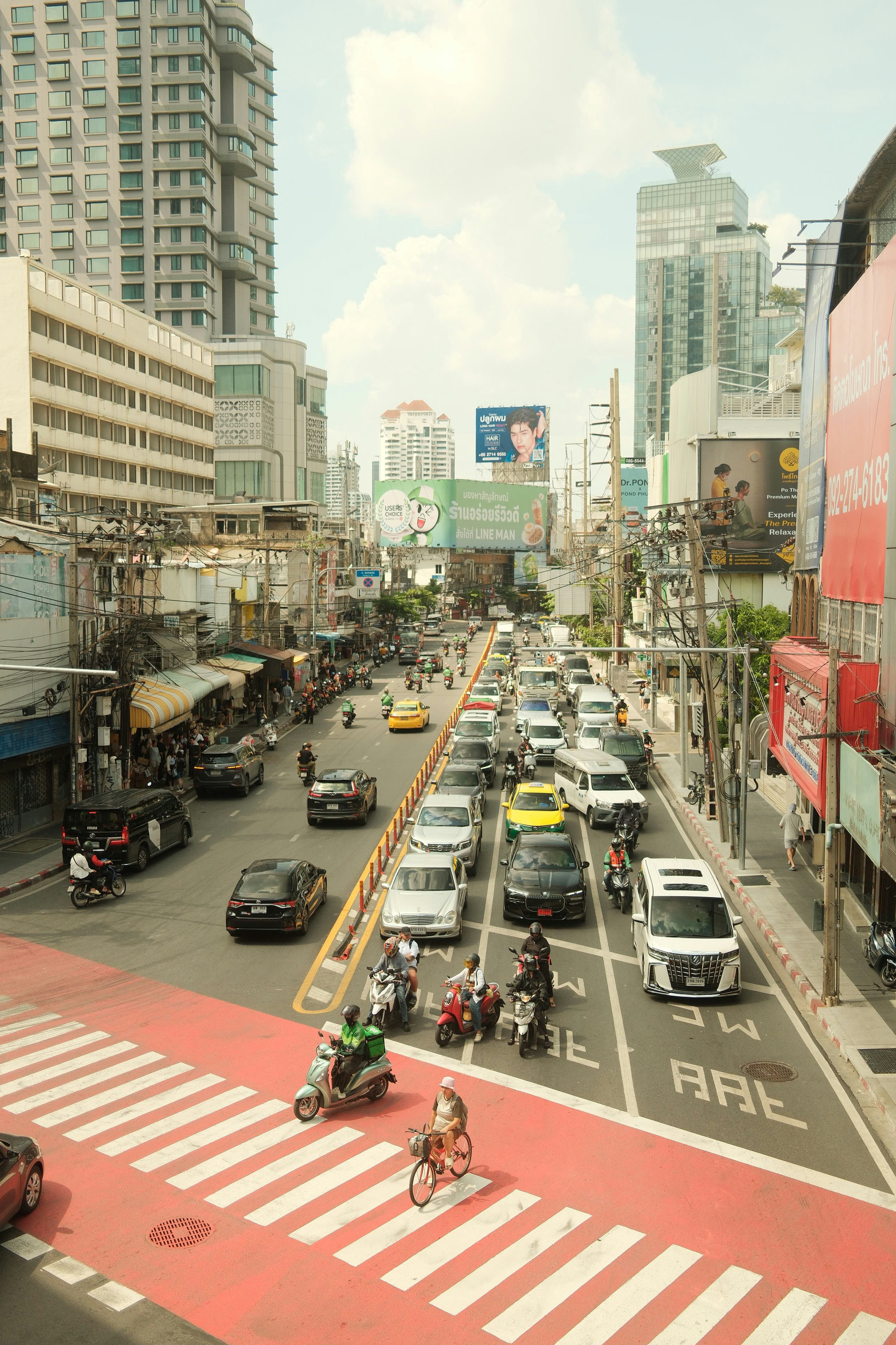 Urban Cascade: A Busy Bangkok Street Routed Through a Red Crosswalk