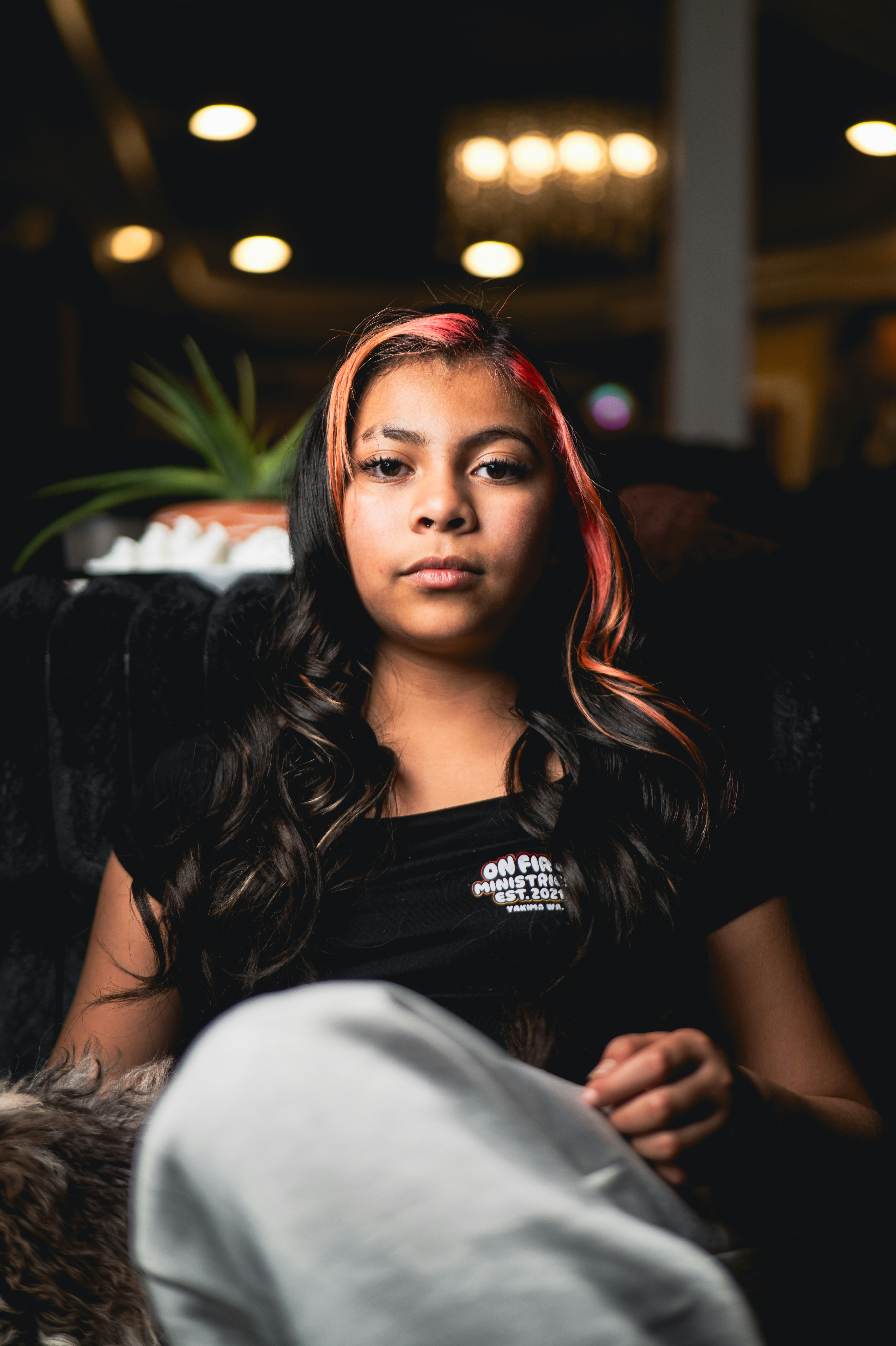 Portrait of a Quiet Moment: A Young Woman with Colorful Hair in Soft Backlight
