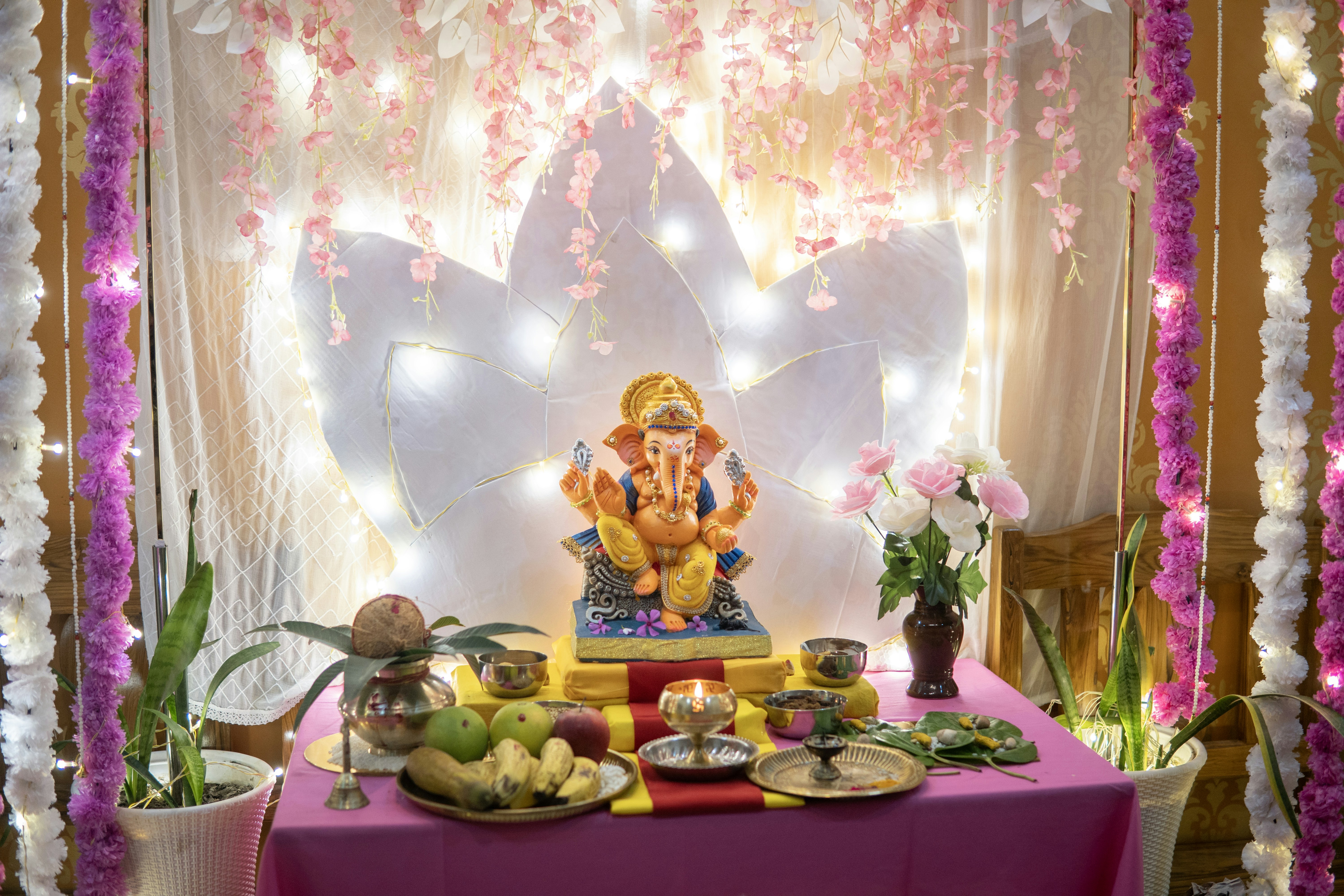 Gleaming Ganesh Altar: A Colorful Sacred Table Shrouded in Floral Light