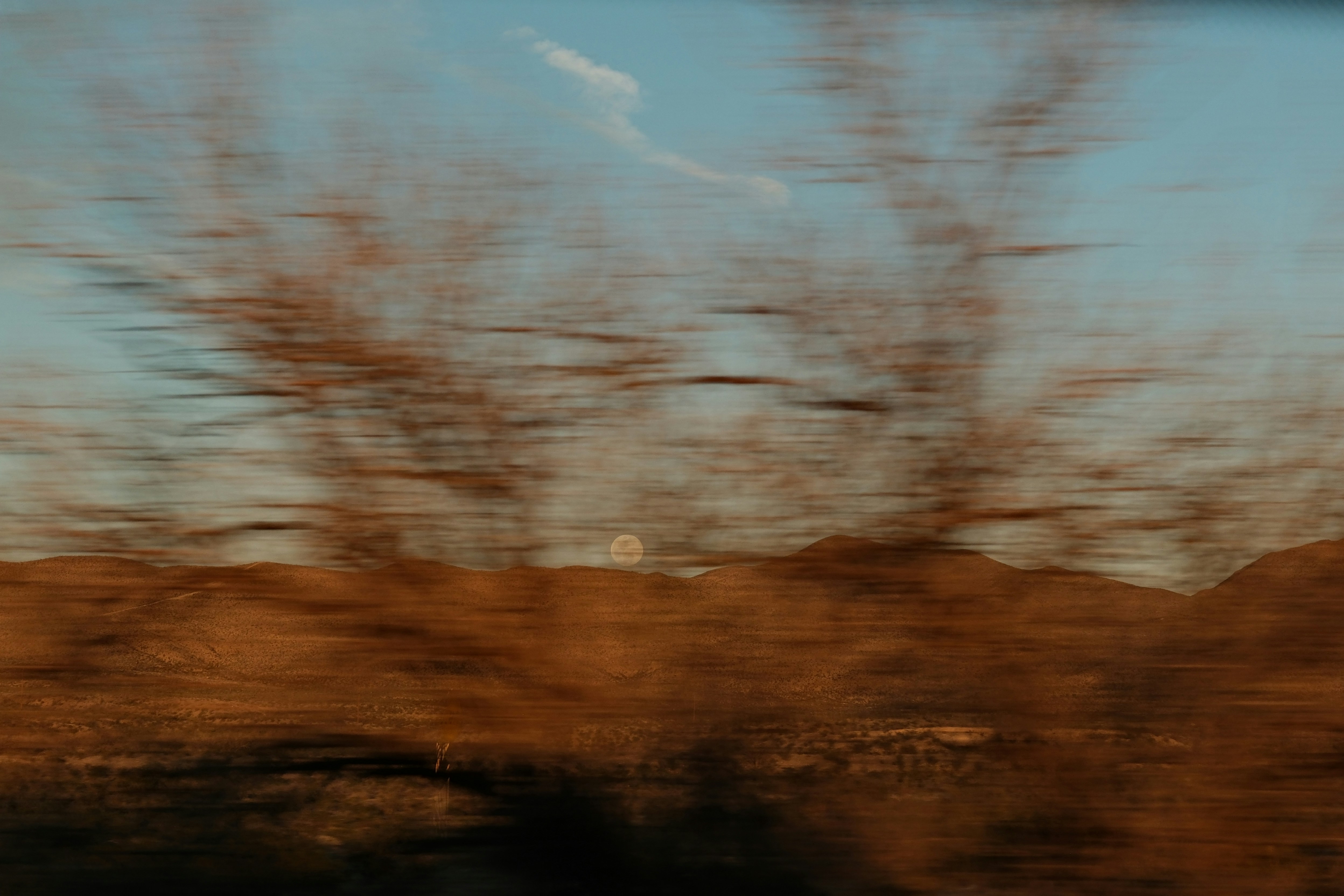 Moonrise over a blurred desert horizon