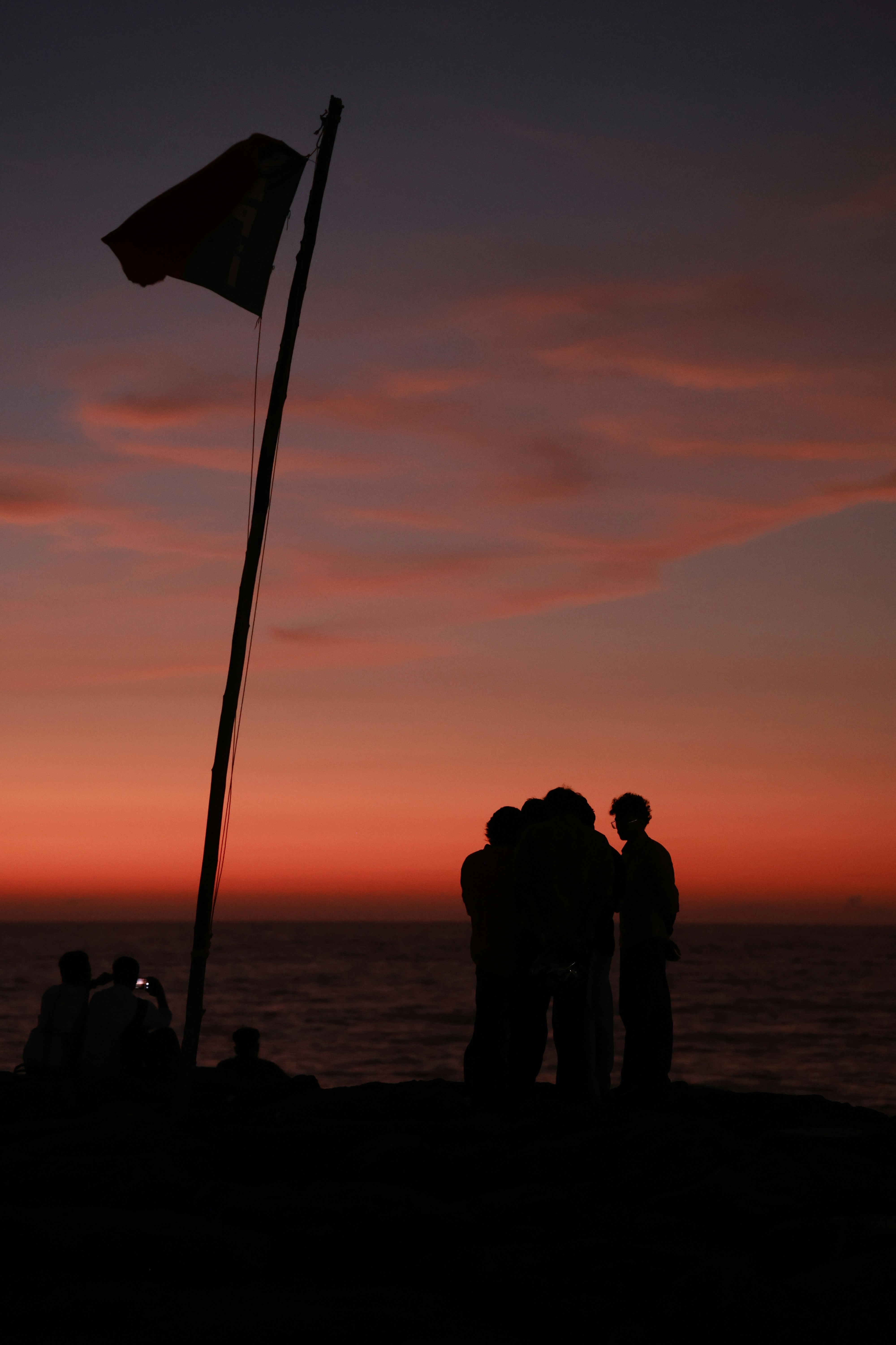 Silhouette at Sunset: A Casual Circle of Friends by the Quiet Sea
