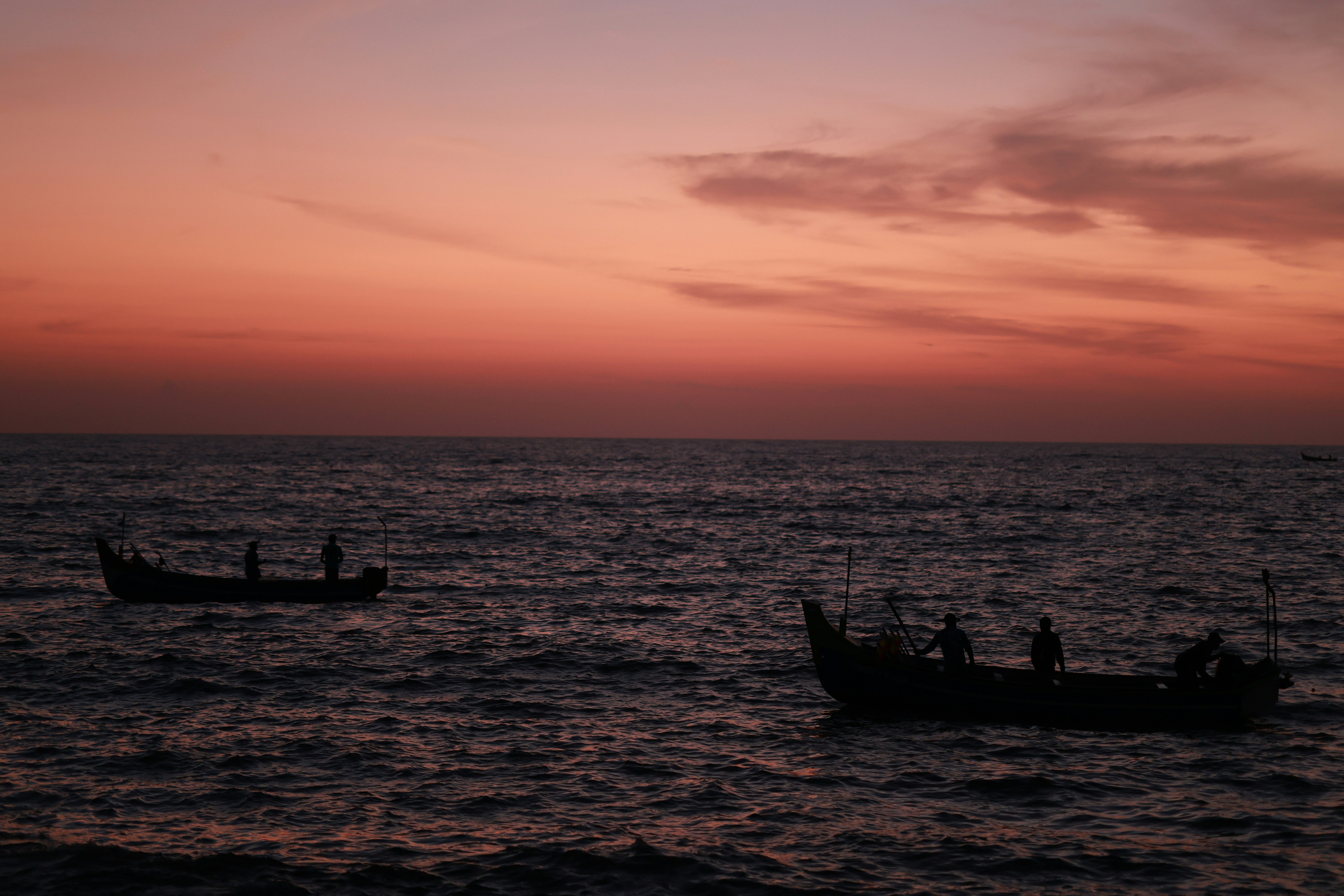 Silhouettes at Sunset: Boats Drift Across a Calm Horizon