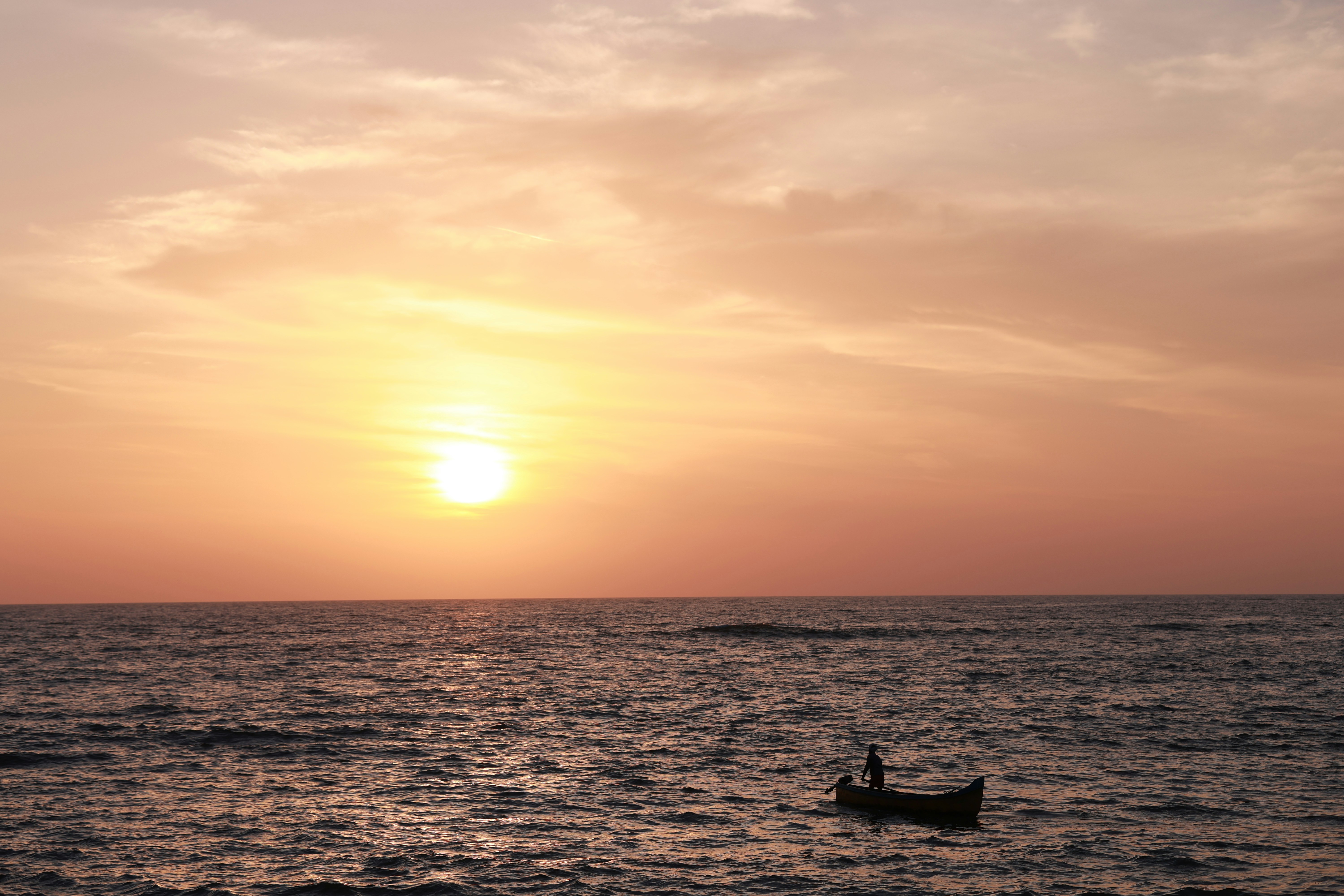 Horizon Sunset with Silhouette: A Lone Boat at Dusk