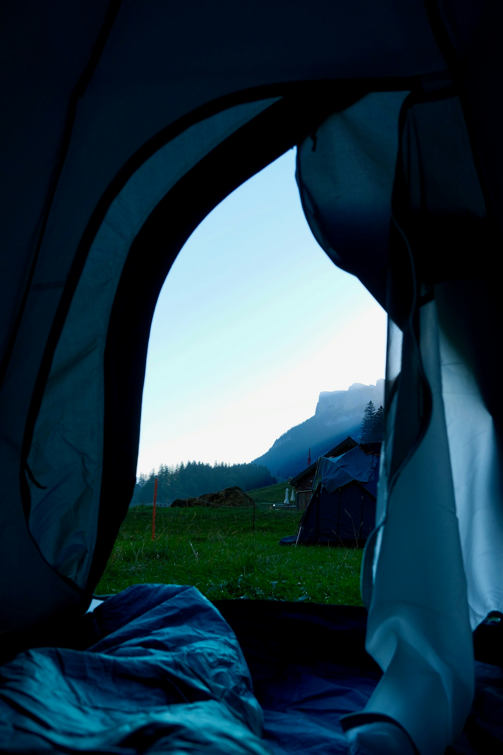 Dawn Light Through a Tent Door Over a Mountain Camp