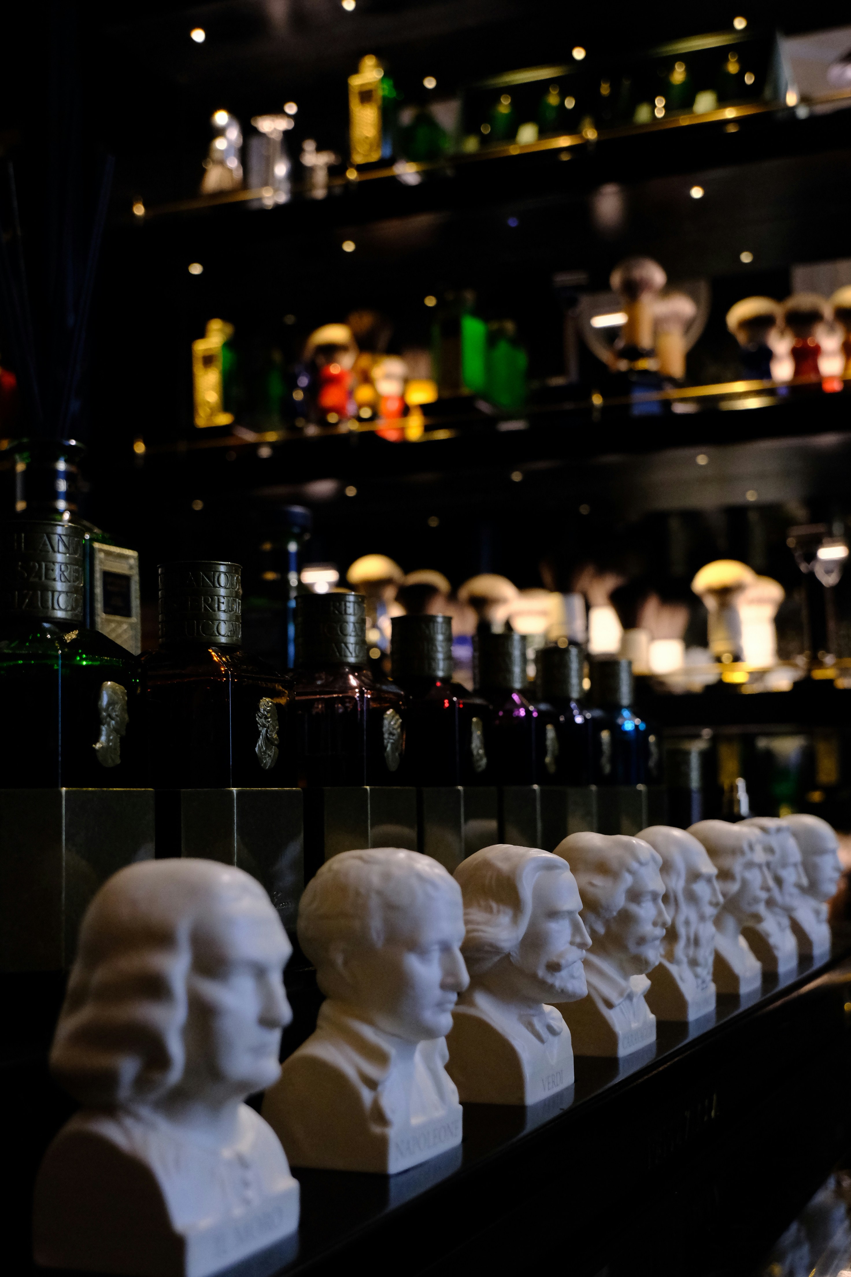 Row of Busts and Bottles: A Quiet Diorama of Collectible Fragrance