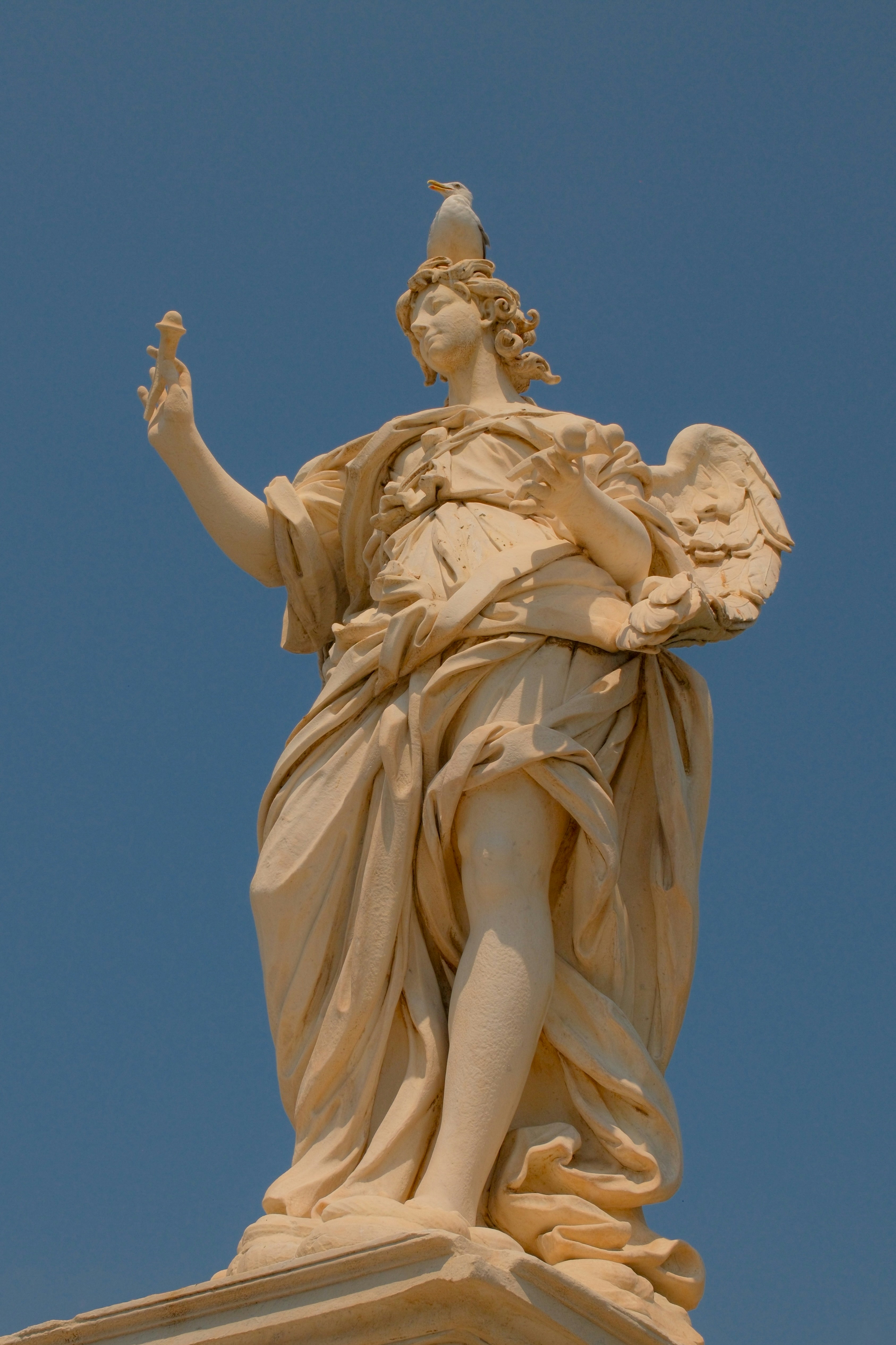 Graceful Sentinel: A marble angel statue against a clear blue sky