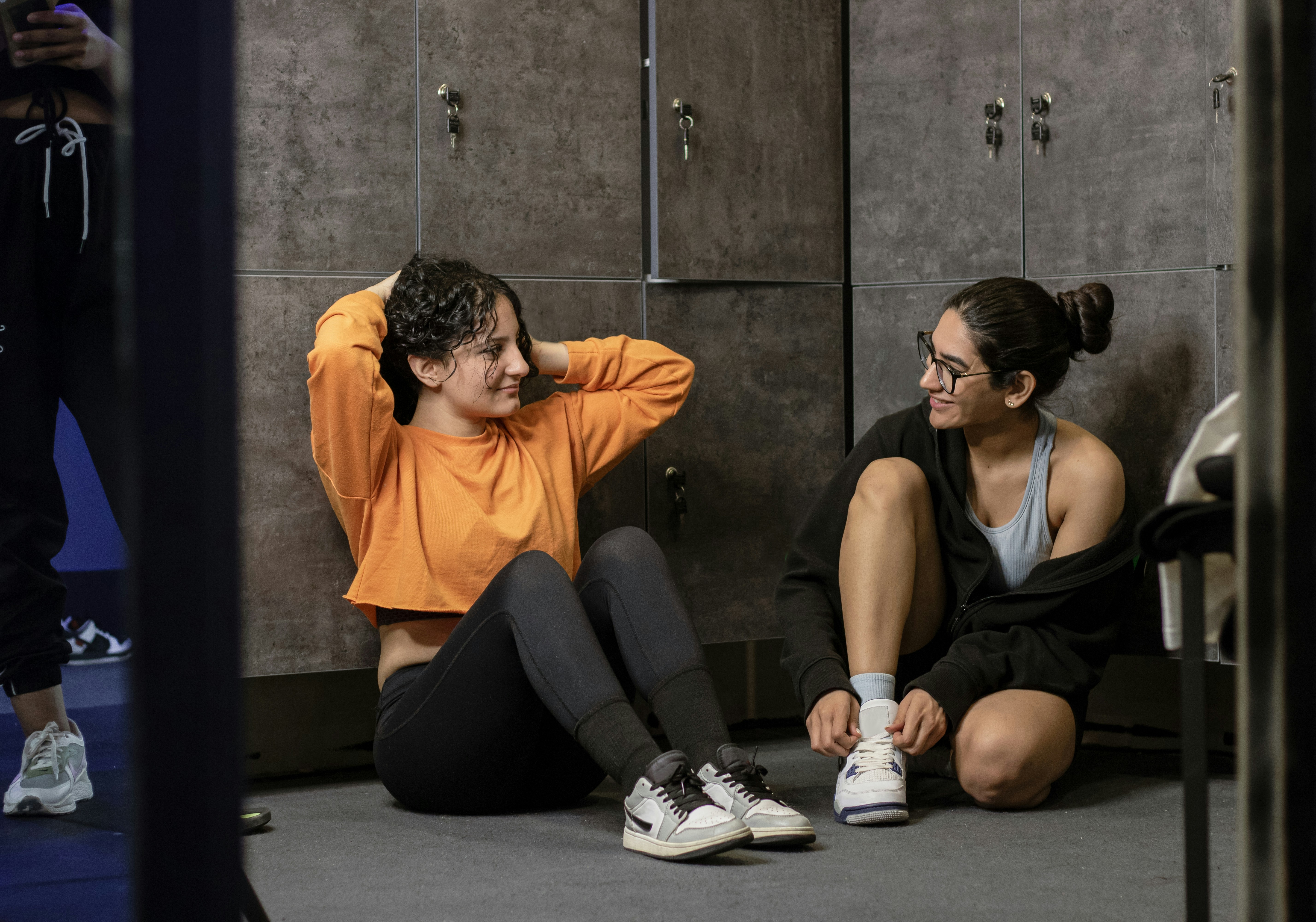 Locker-room confidants: a candid moment between friends indoors