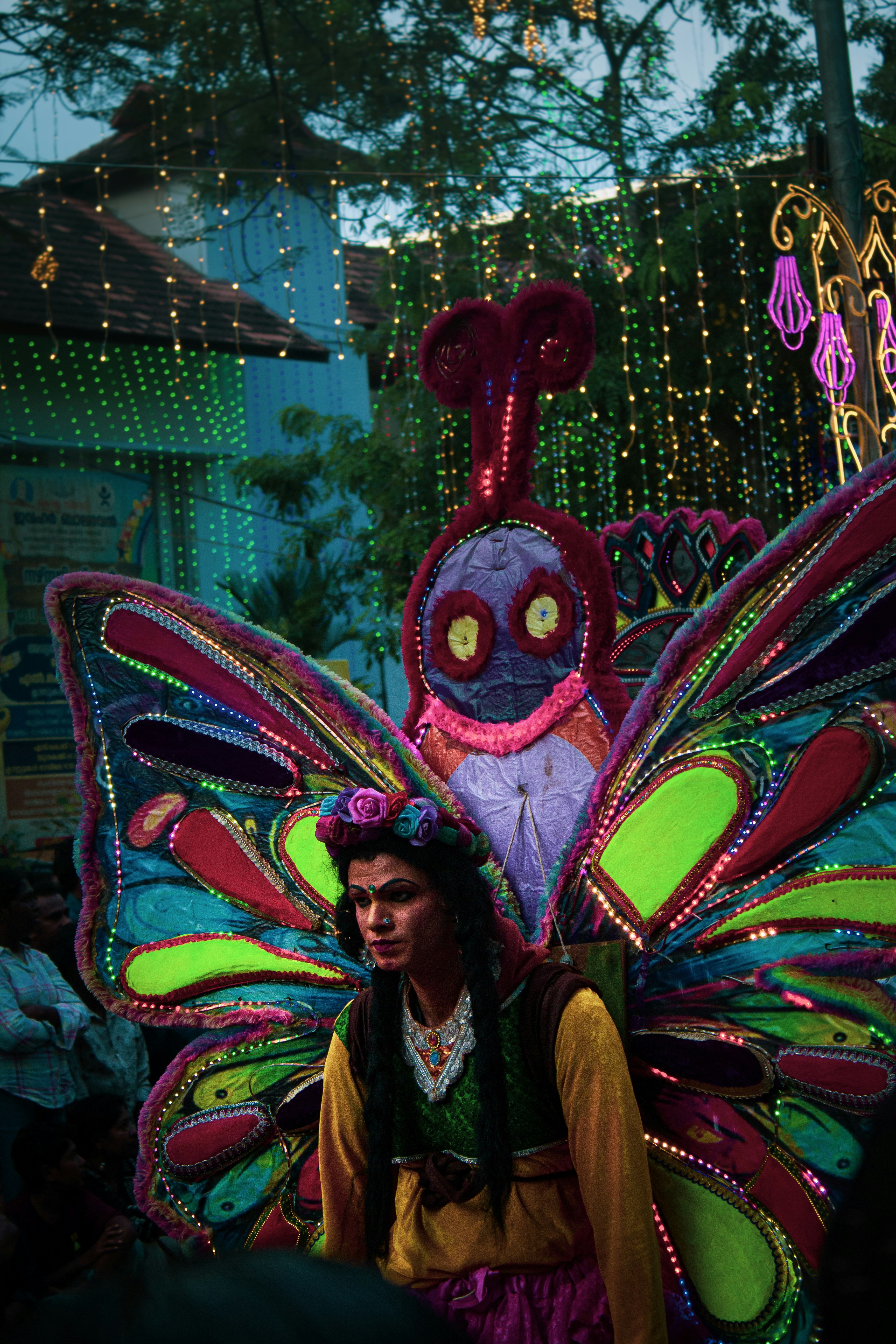 Colorful Winged Performer Under Celebratory Lights