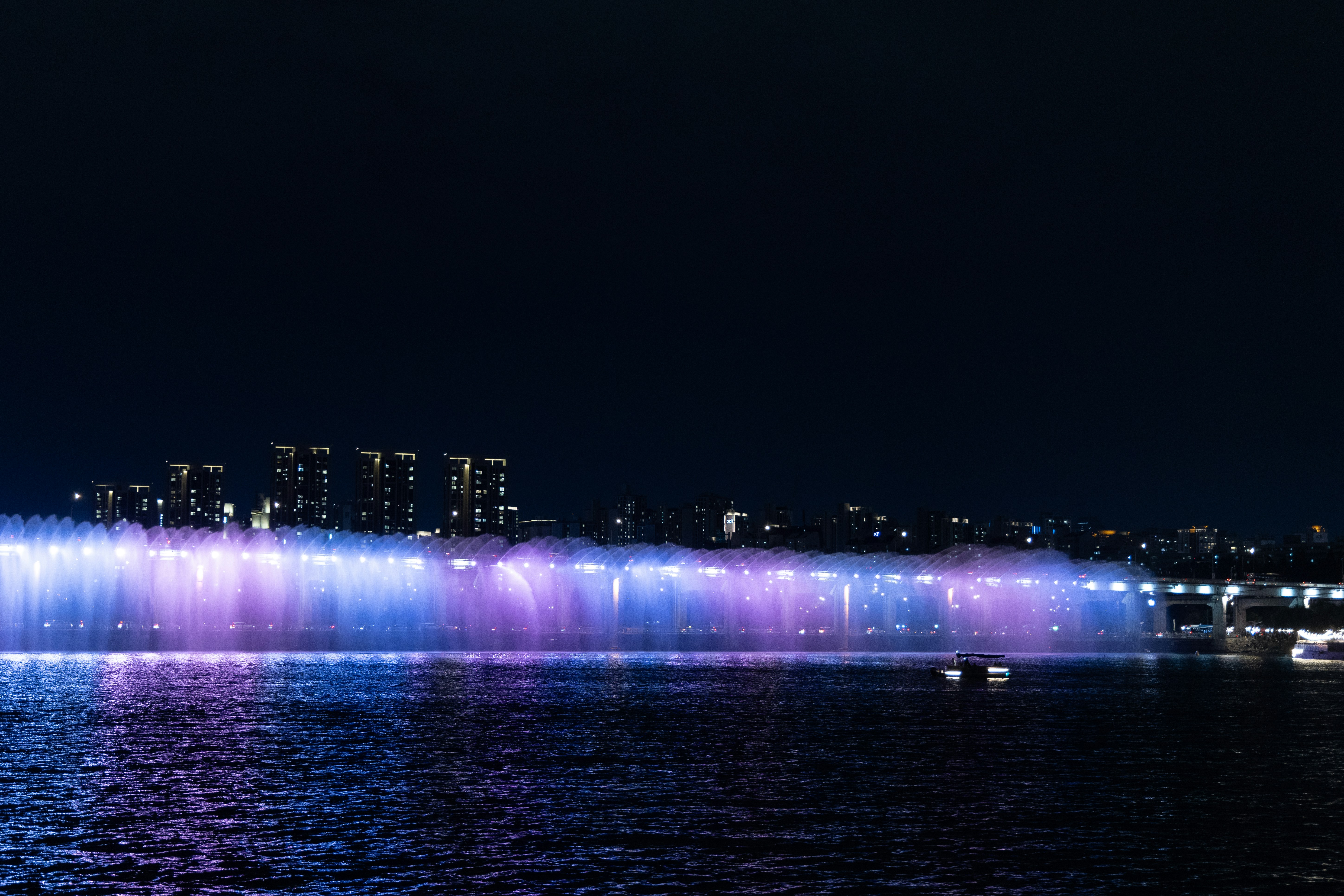 Neon Cascade: A river of violet light across the night harbor
