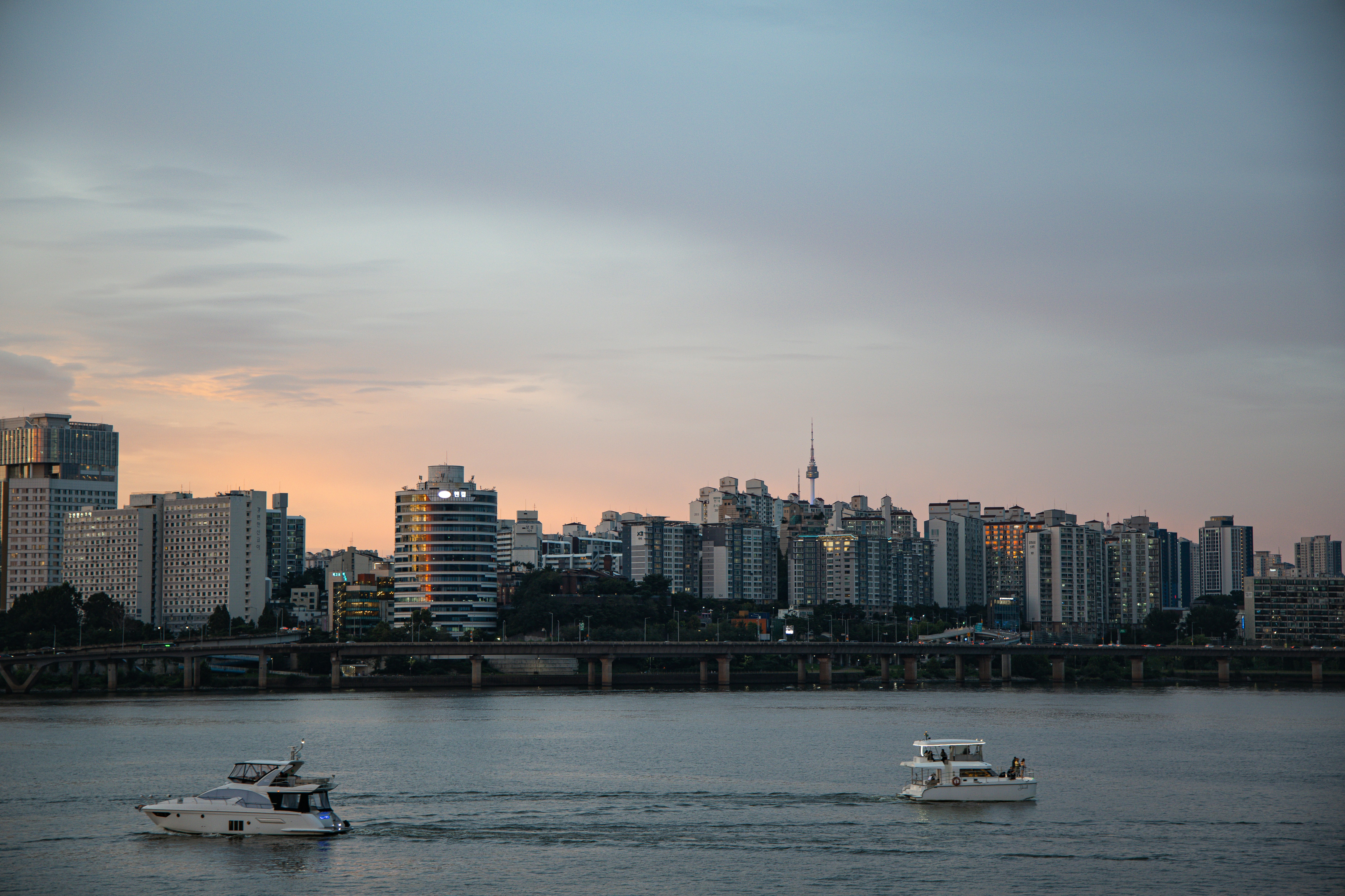 Harbor Skyline at Dusk: Boats Silhouetted by a Calm River