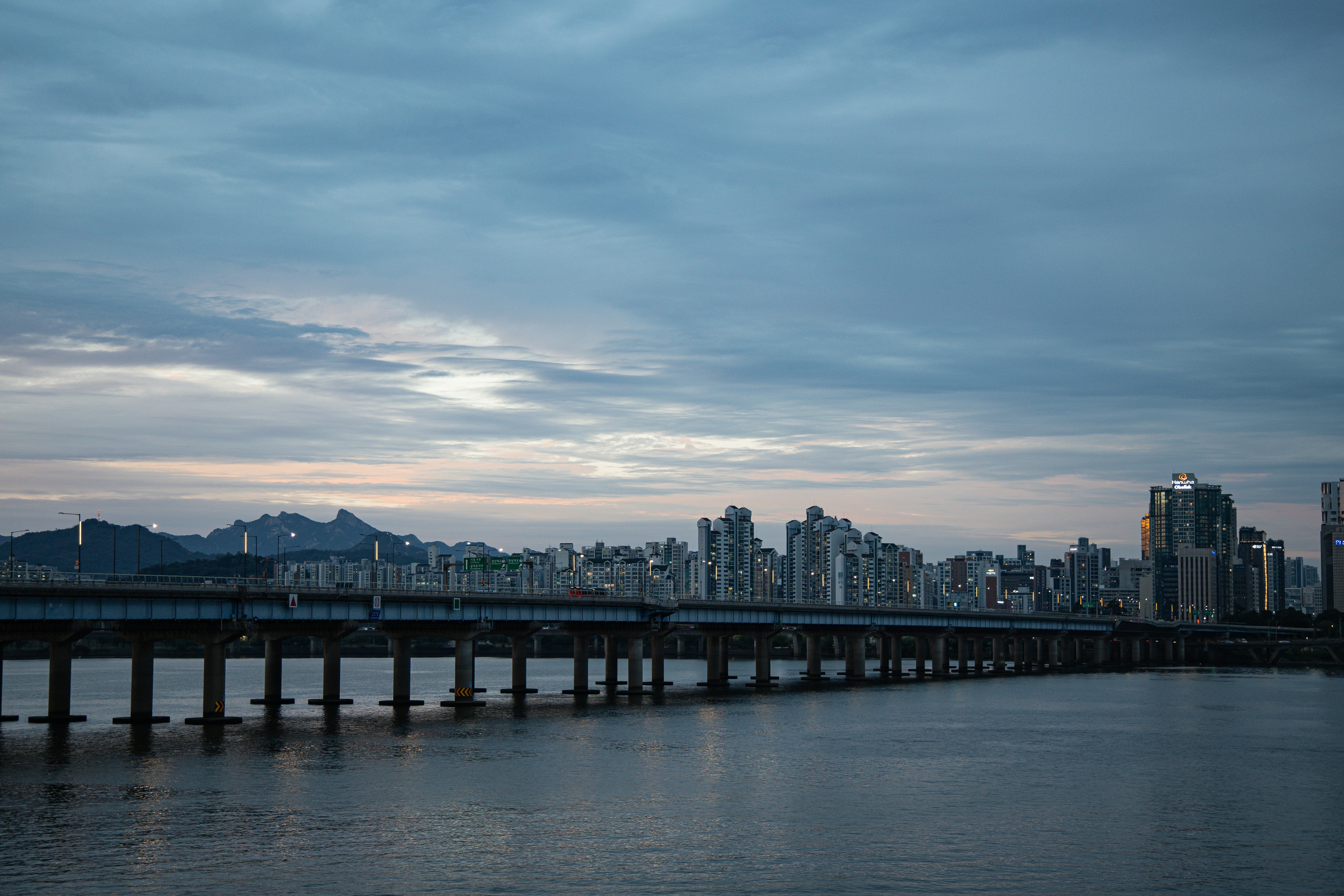 Dawn on the Riverfront: Skyline Awakening Over Calm Waters
