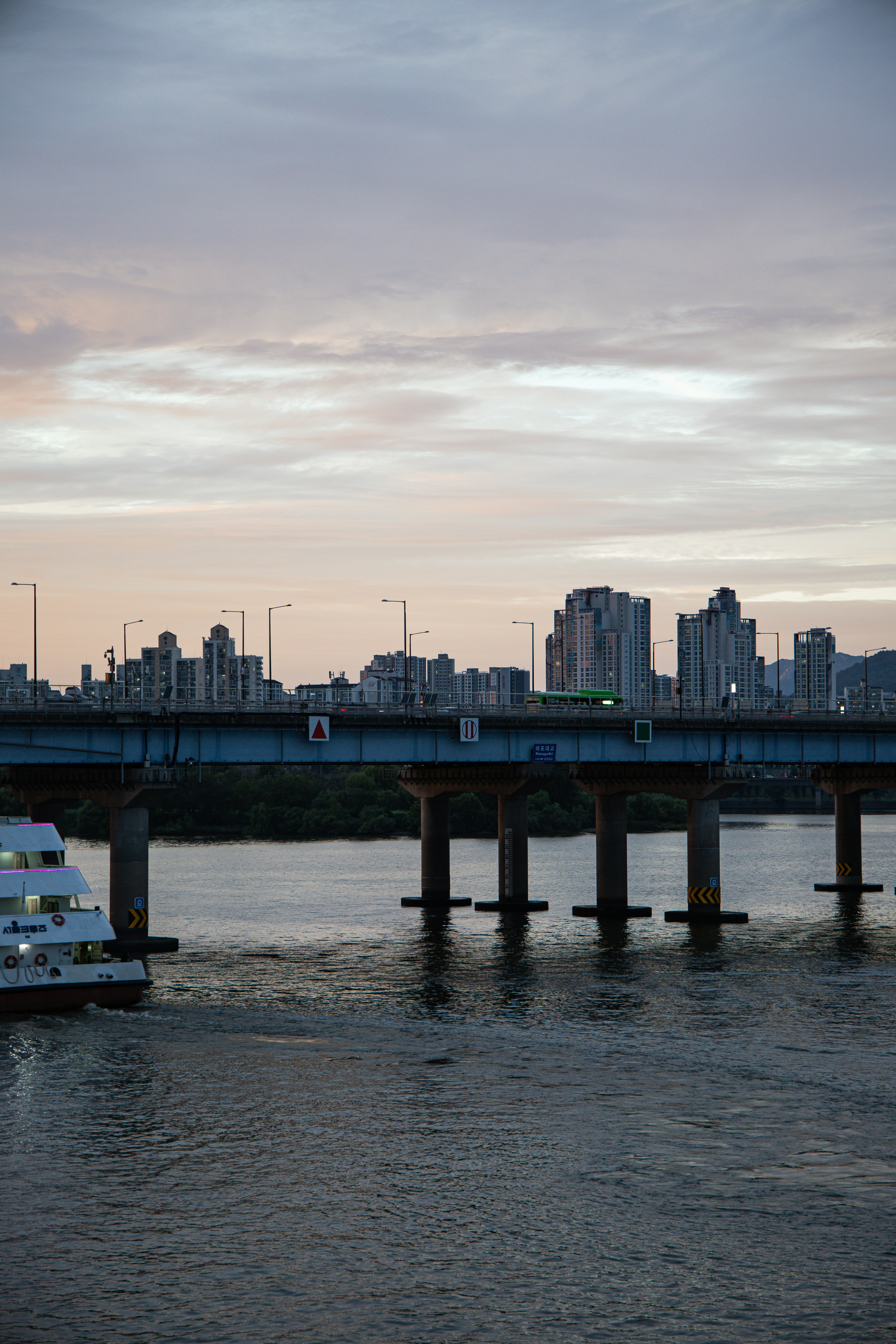 Cityscape over the River: Bridge, Buildings, and a Distant Vessel