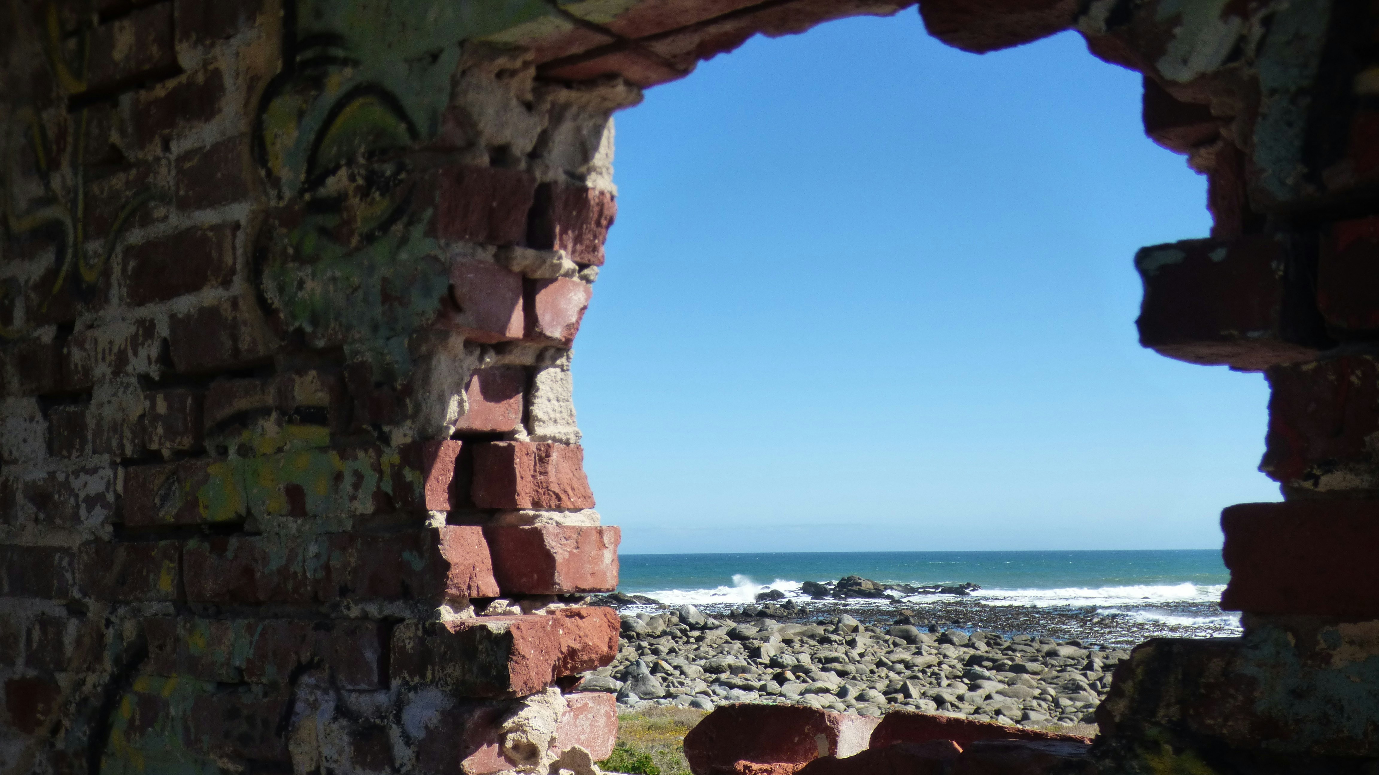 Rusted Archway Framing a Seaside Horizon