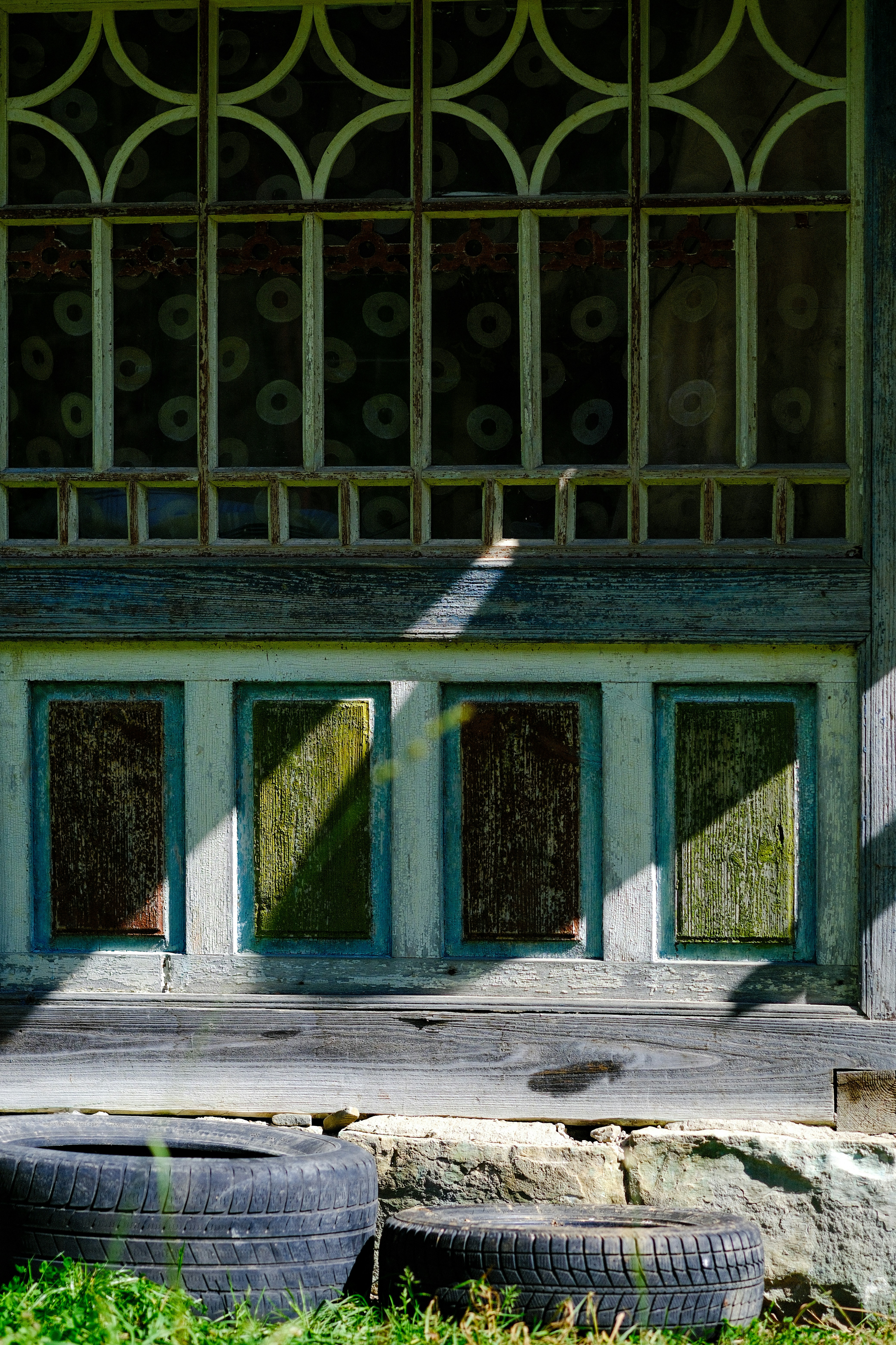 Weathered Doorway Framed by Circular Grille and Recycled Tread