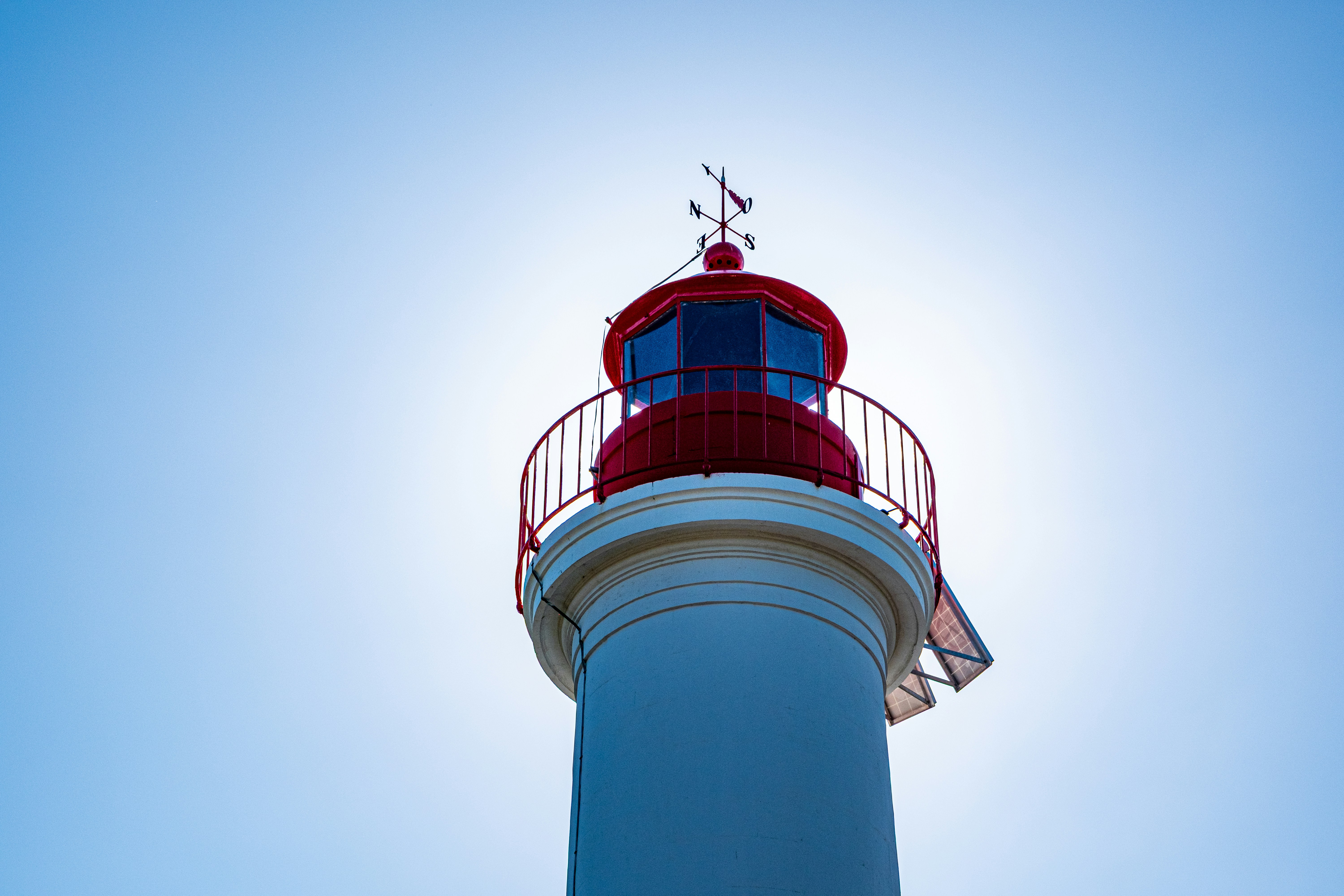 Coastal Beacon: The Red Lantern Rising Above Cerulean Sky