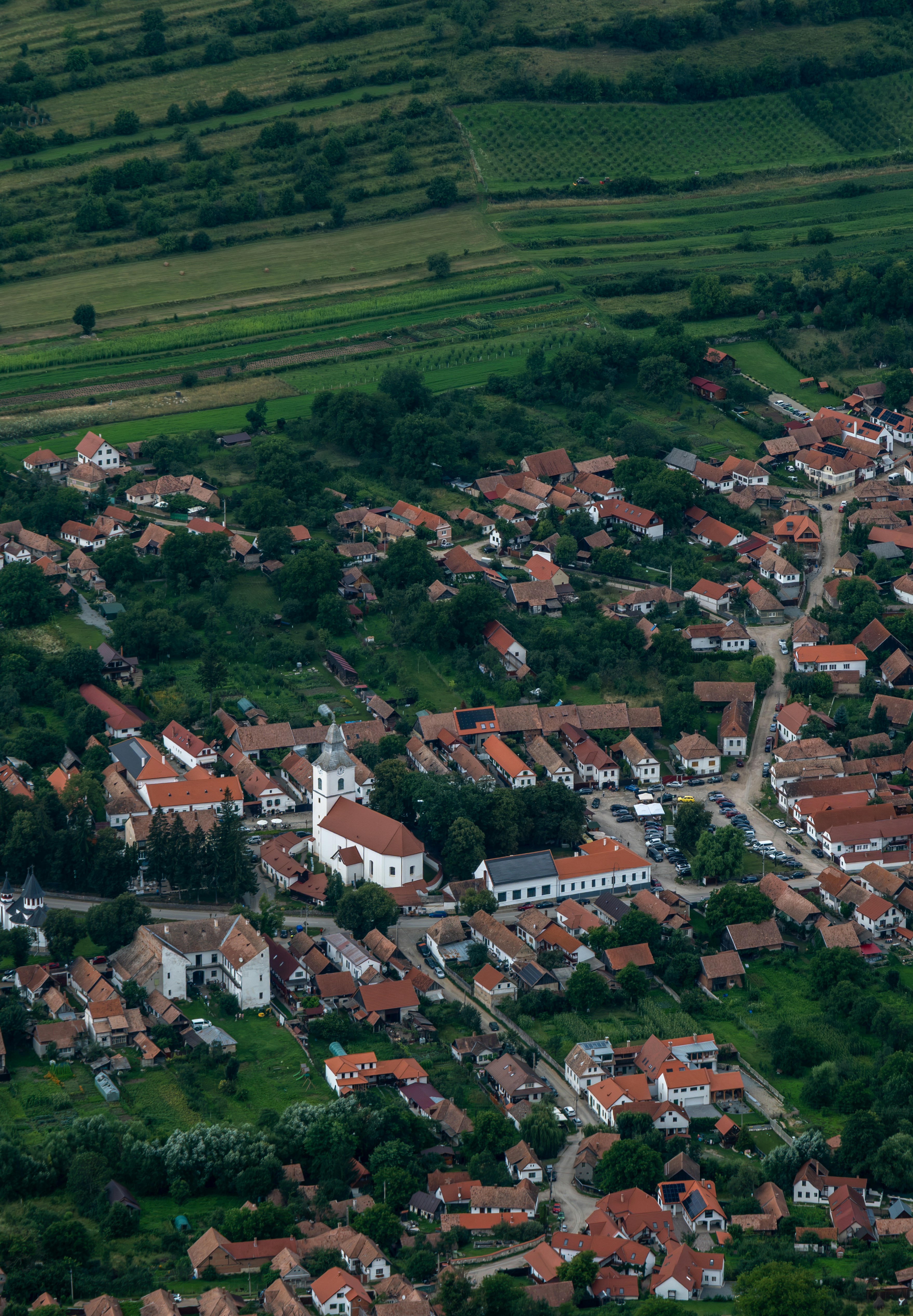 Village quilted with red roofs under patchwork farmlands