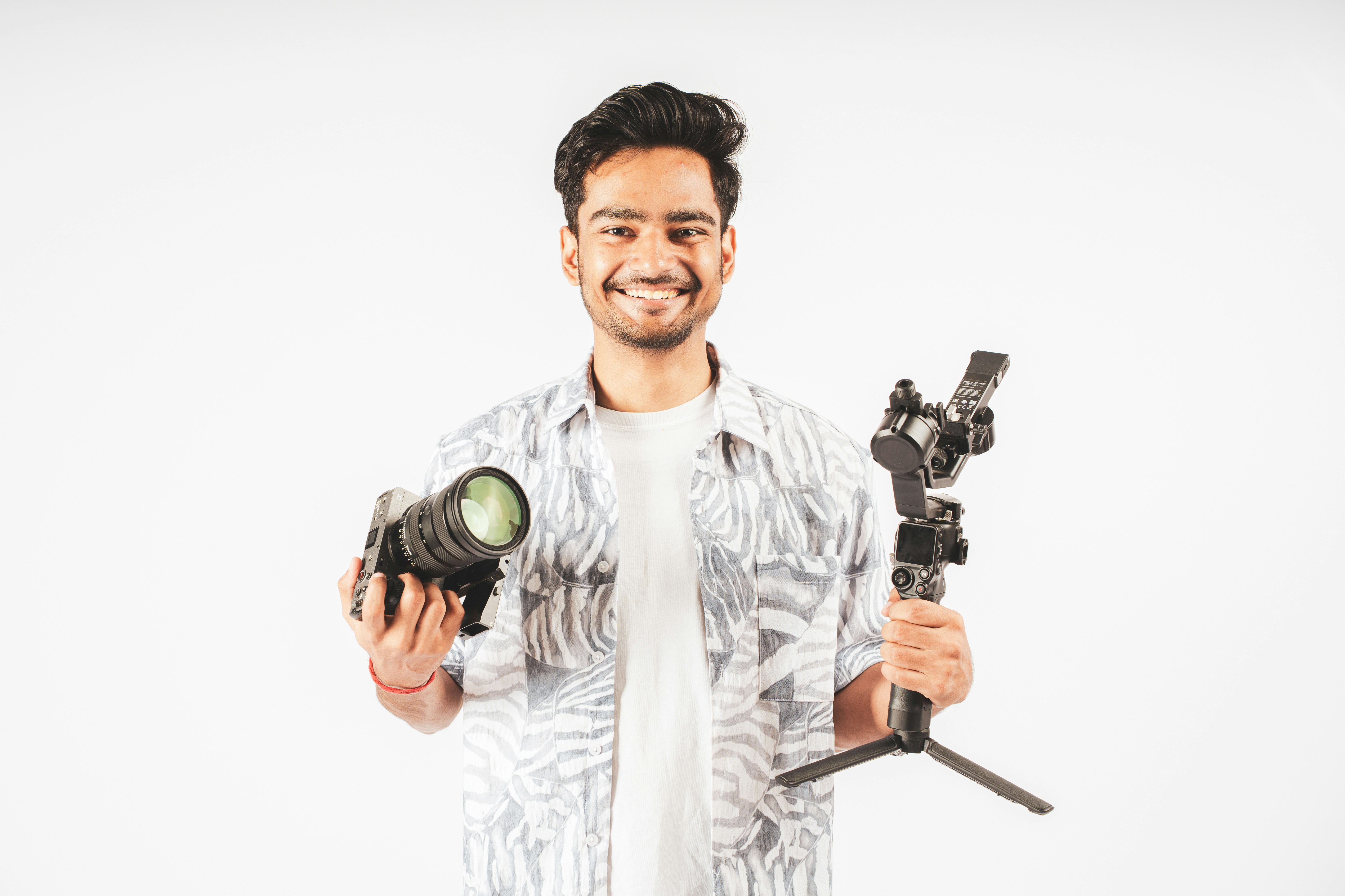 Portrait of a confident videographer with camera rig in a bright studio