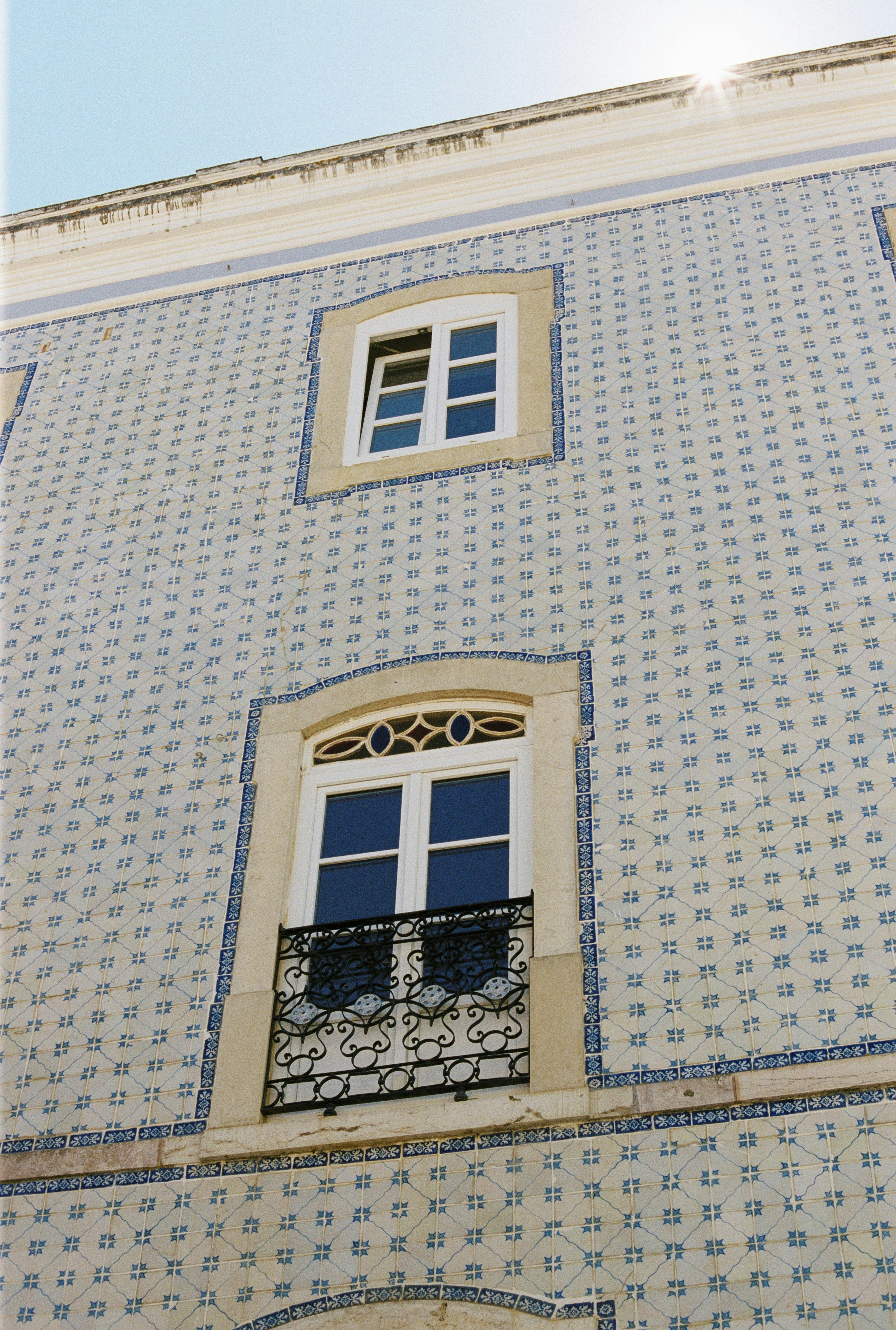 Blue Tiles and Balcony Vista: A Portuguese Facade Under Bright Sky