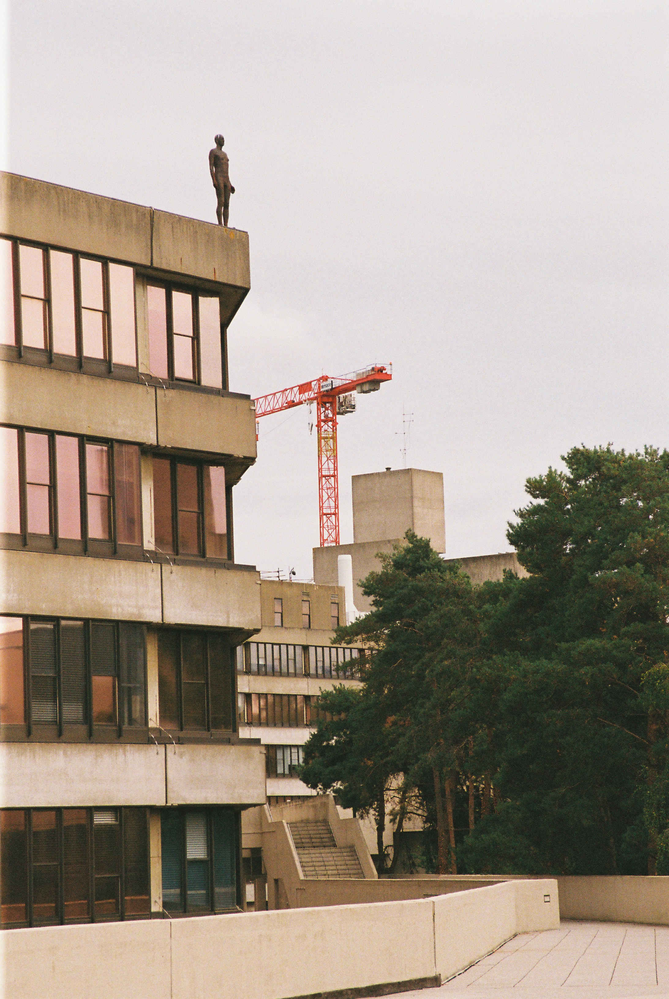 The Rooftop Statue Overlooking a Construction Crew