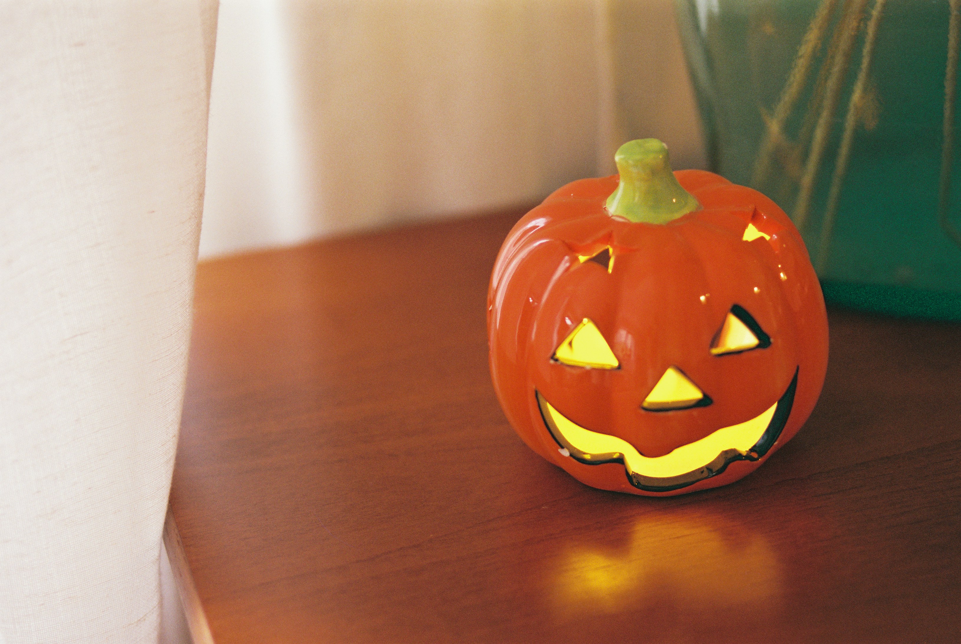 Carved Glow: A Mini Halloween Jack-o’-Lantern on a Wooden Table