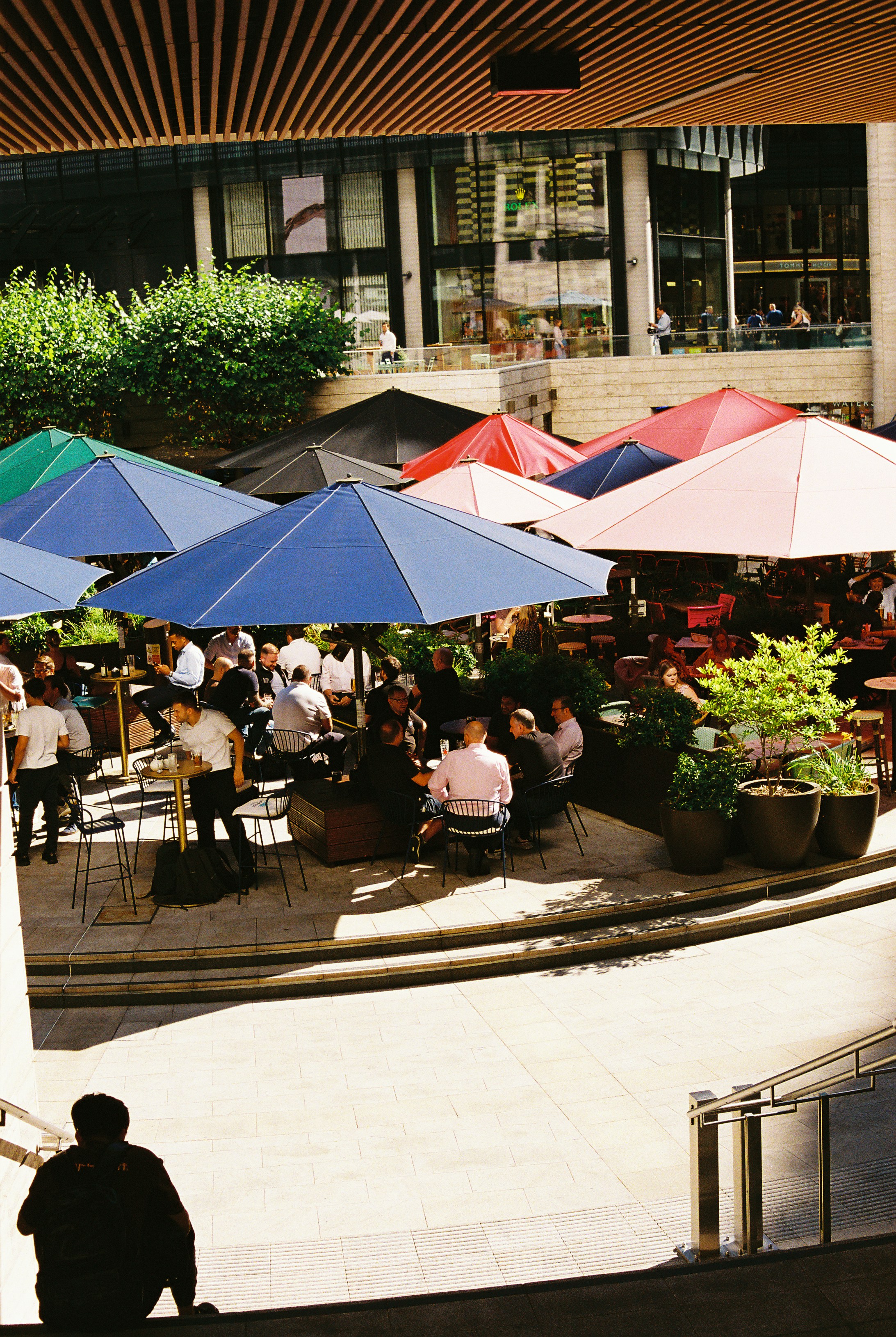 A Sunlit Courtyard Café with Multicolored Umbrellas