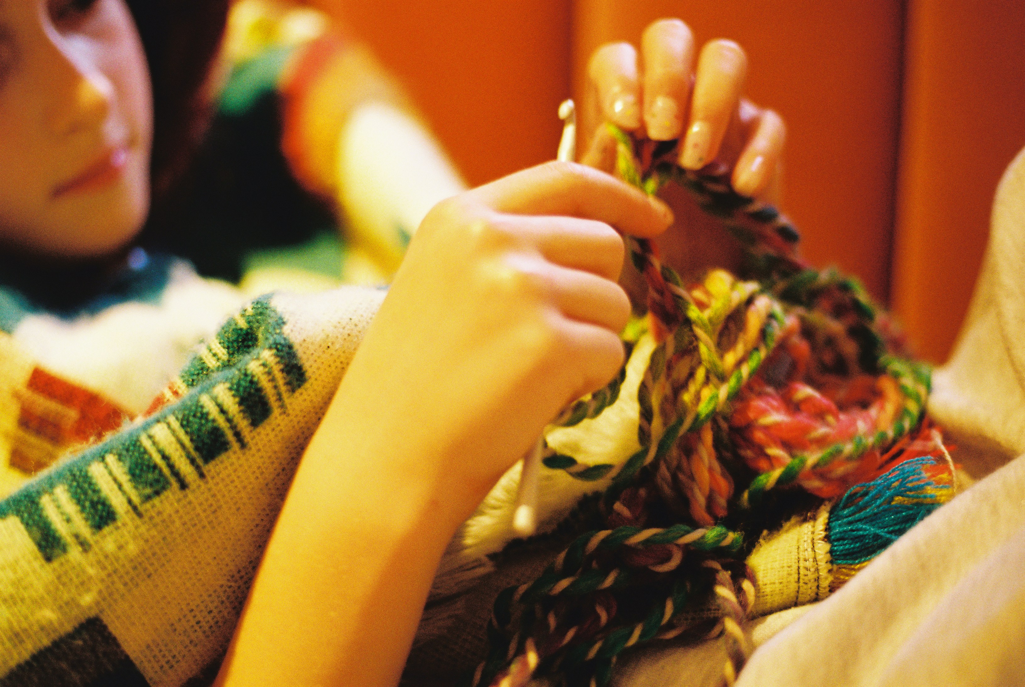 Hands in Colorful Knit: Crafting Focus in Warm Light