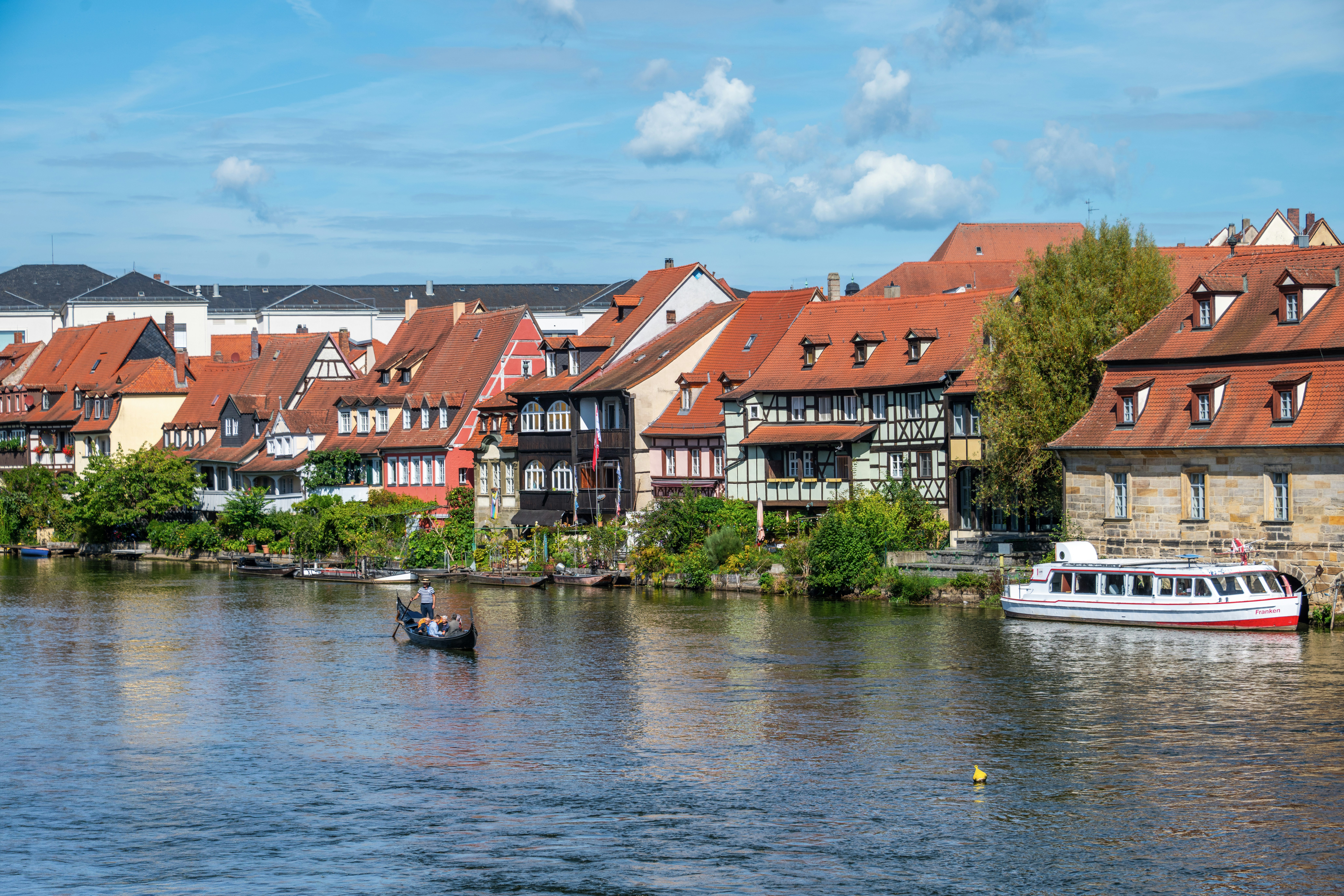 Riverside Row of Timbered Homes Under a Bright Bavarian Sky