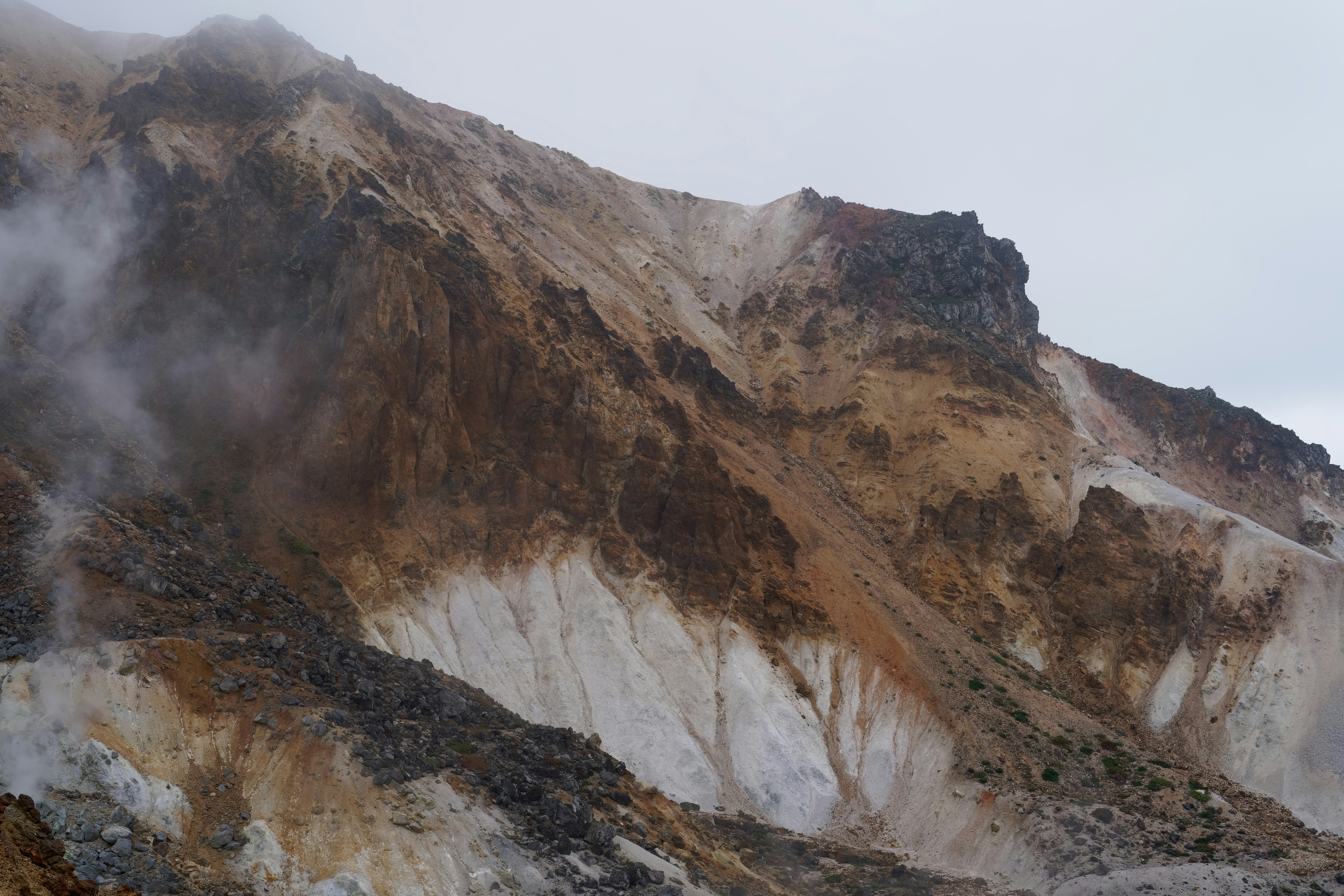 Striated Peak: Earth Tones and Veiled Steam at Dawn