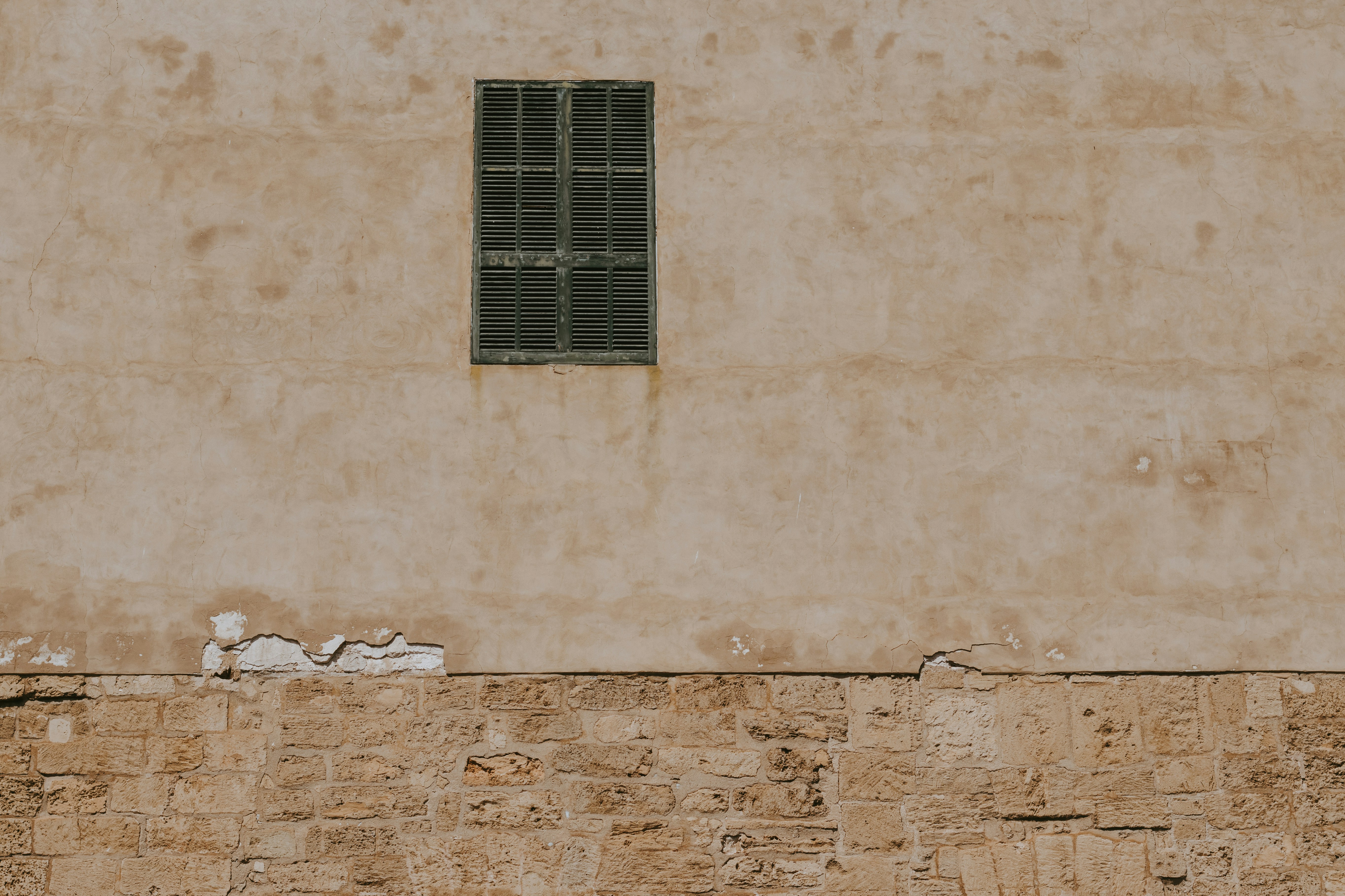 Weathered Windowsill: A Quiet Facade of Stone and Plaster
