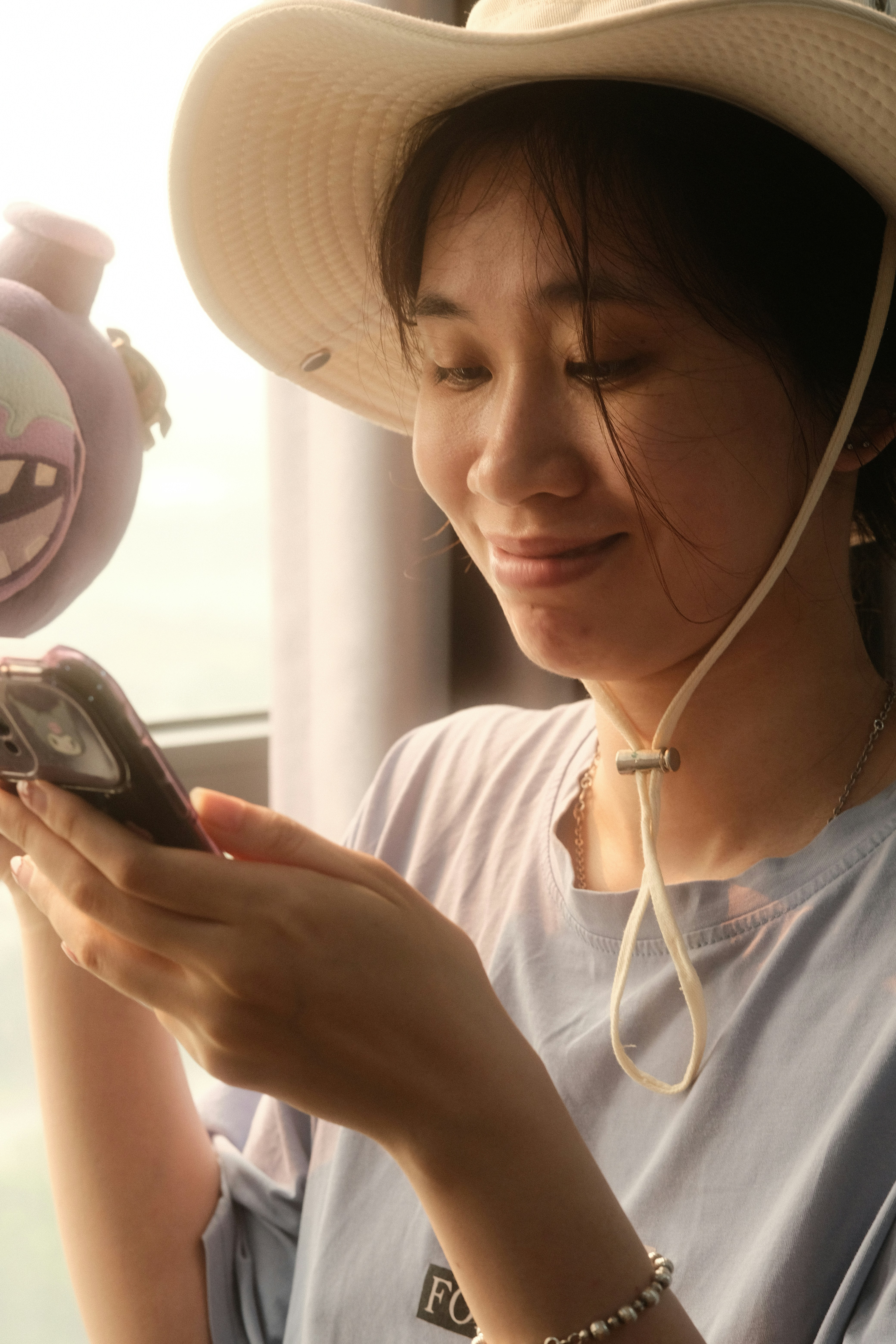 Sunny Hat, Soft Glow: A Moment with a Phone